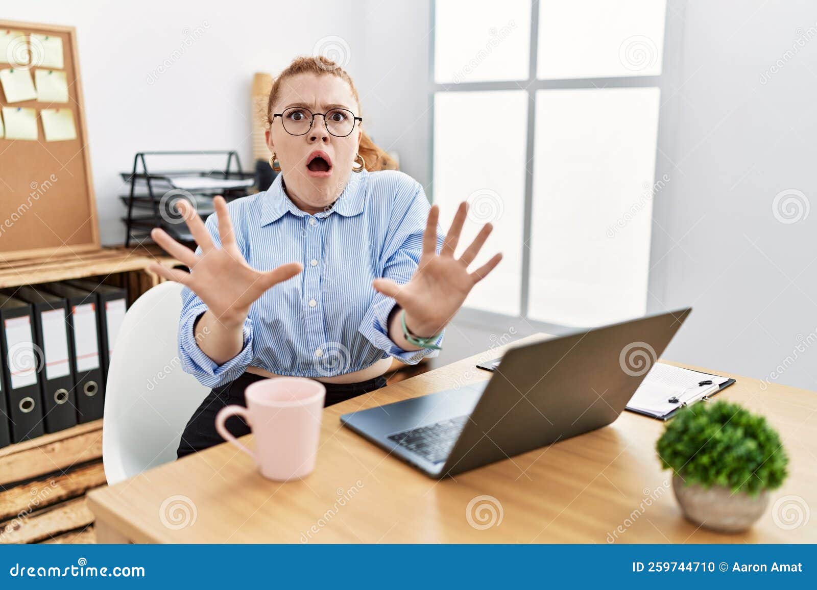 Young Redhead Woman Working at the Office Using Computer Laptop Afraid ...