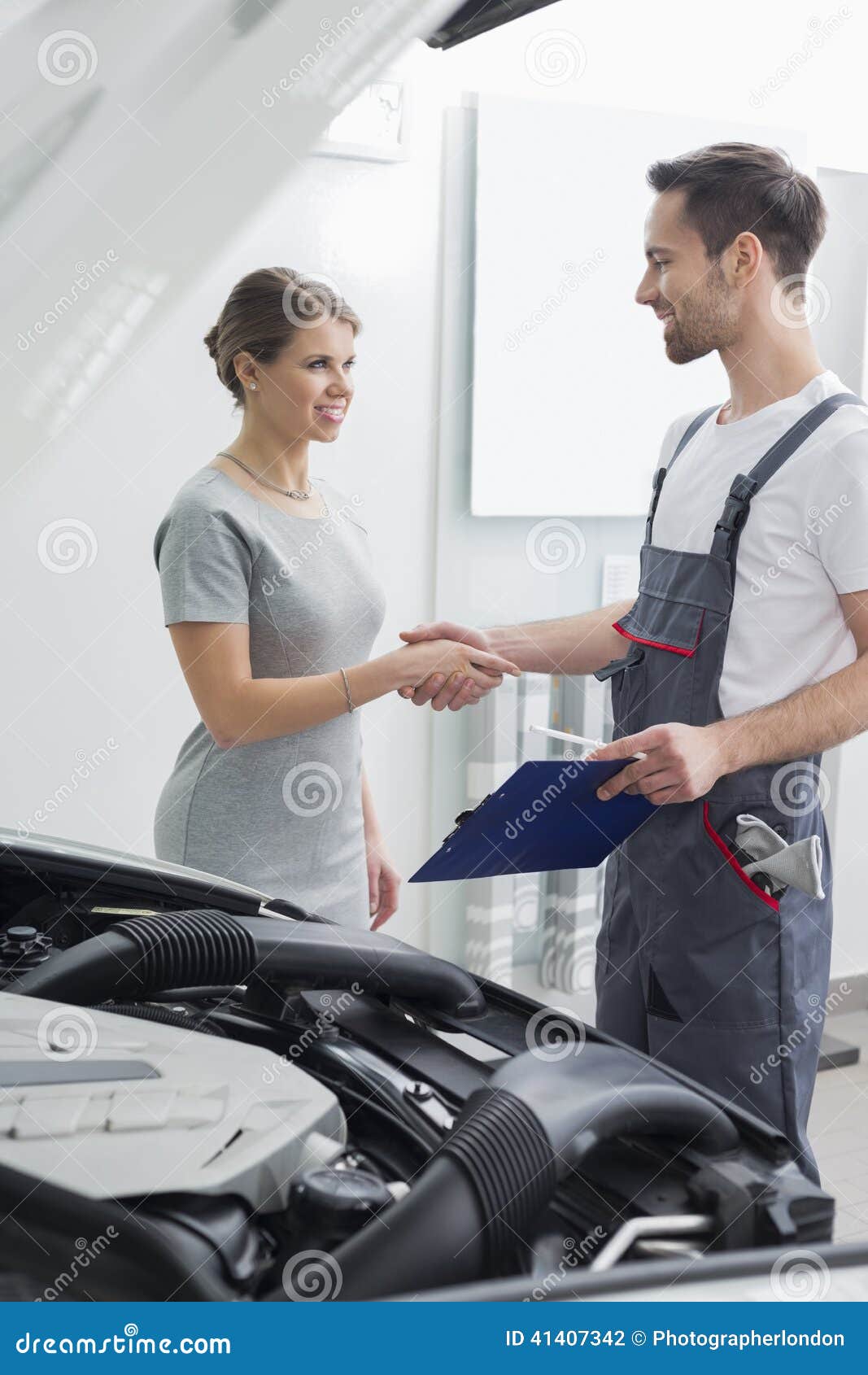 Young Repair Worker Shaking Hands with Customer in Car Workshop Stock ...