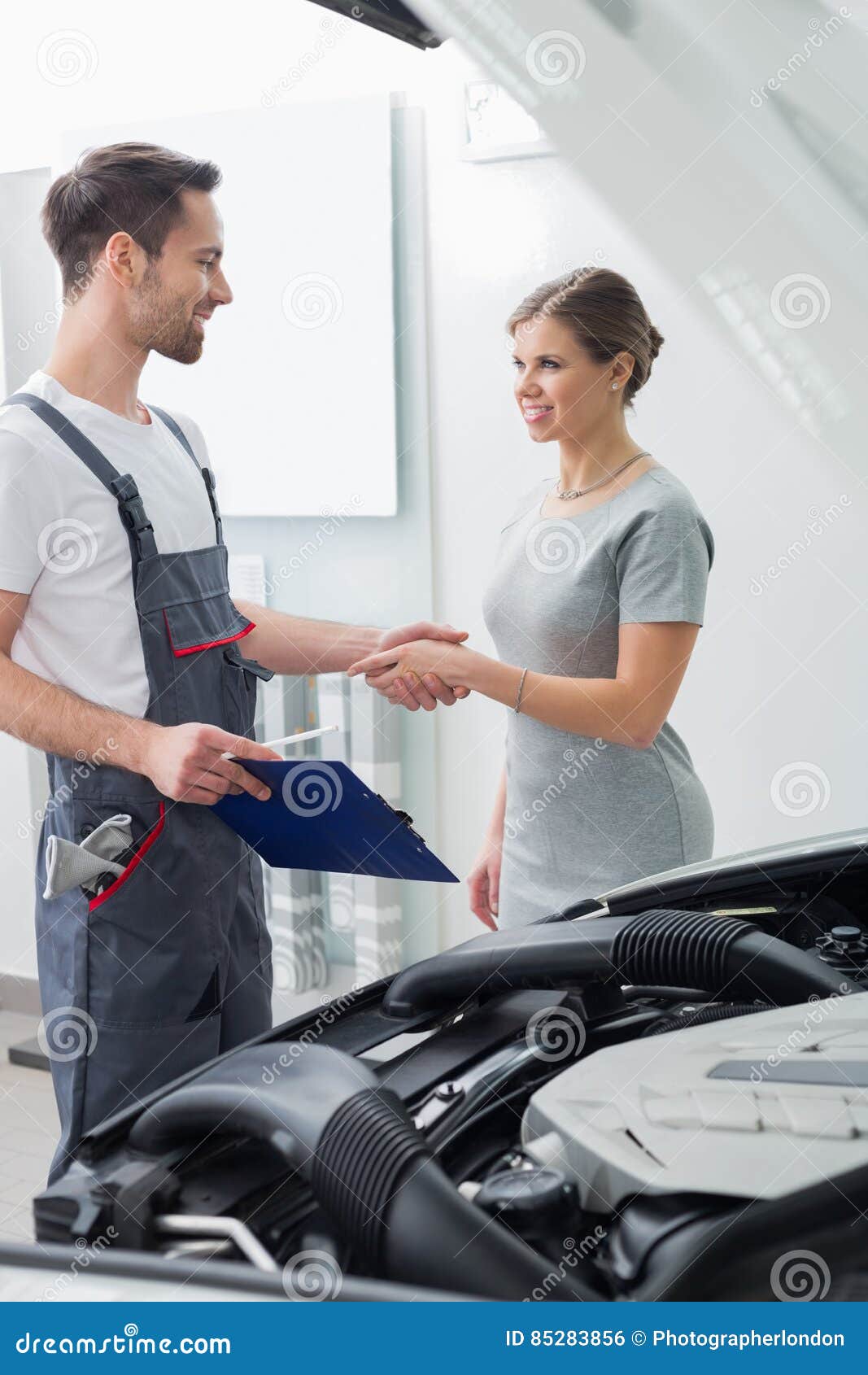 Young Repair Worker Shaking Hands with Customer in Car Workshop Stock ...