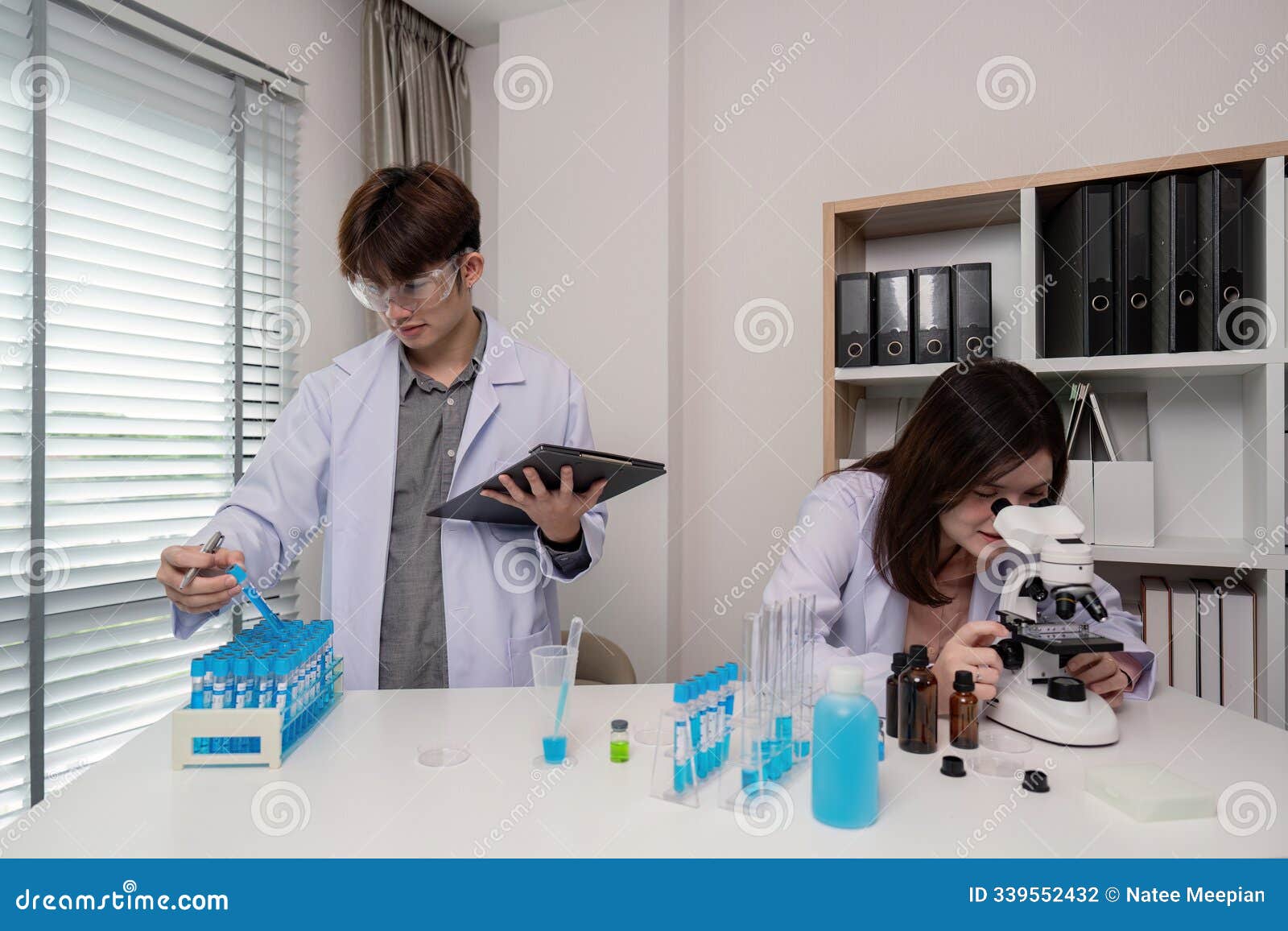 Researcher Performing Dual Experimentation: Microscope Analysis and ... Researcher Performing Dual Experimentation: Microscope Analysis and ...