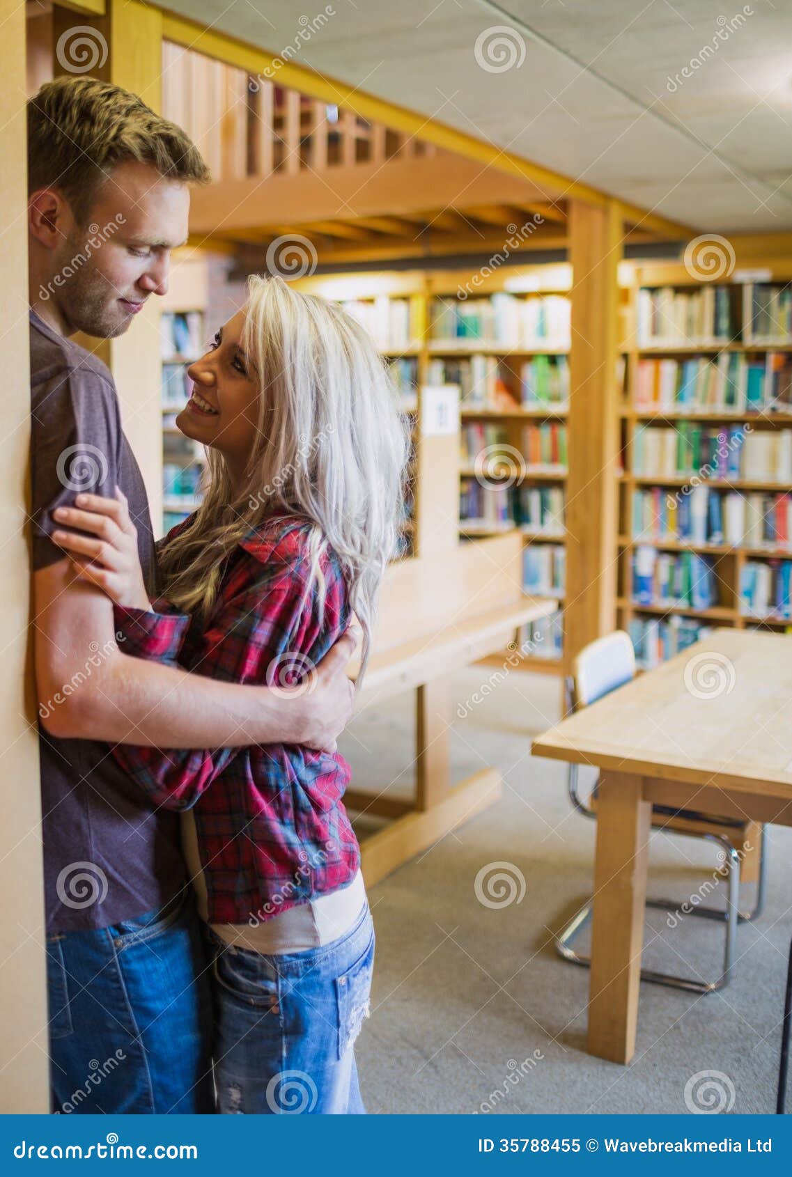 Young Romantic Couple with Bookshelf at Distance in Library Stock Image ...