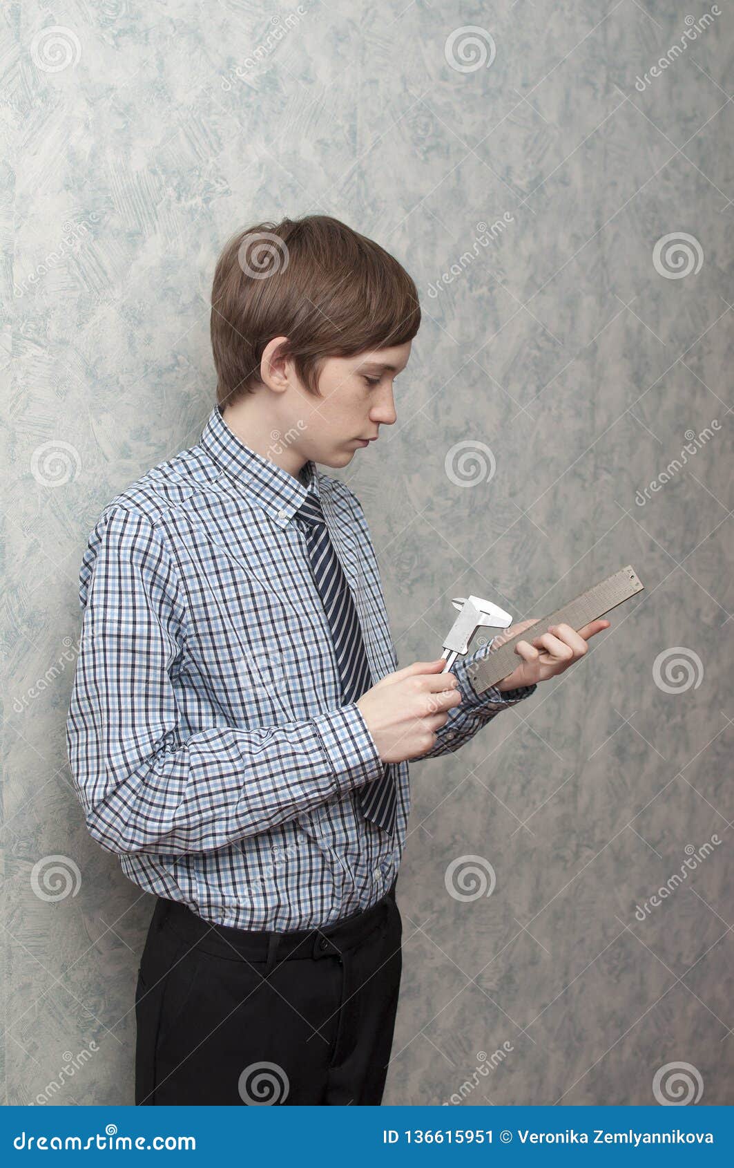 The Young Russian Guy Holds a Caliper and a Metal Ruler in Hand Stock ...
