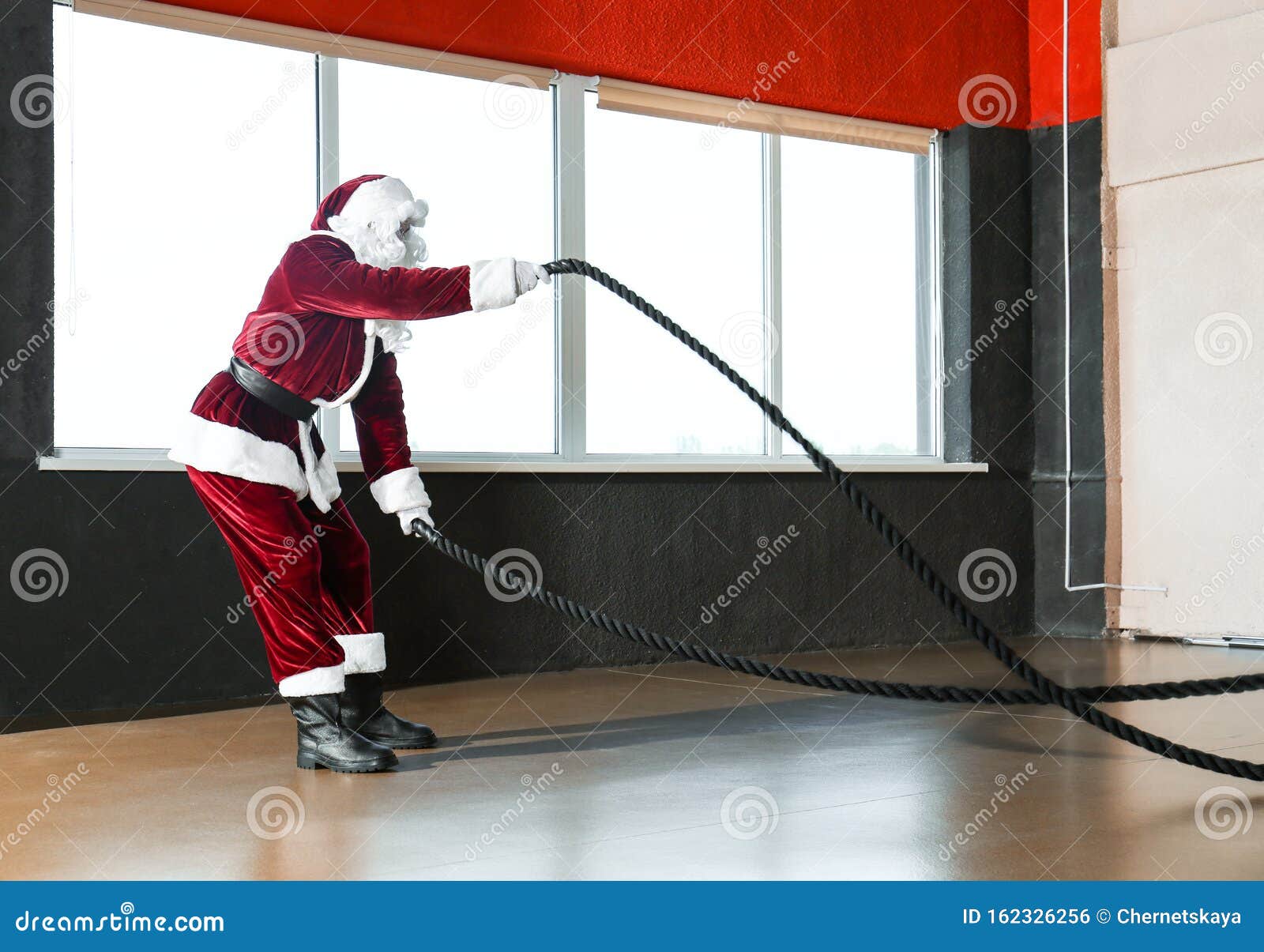 Young Santa Claus Training with Ropes in Gym Stock Photo - Image of ...