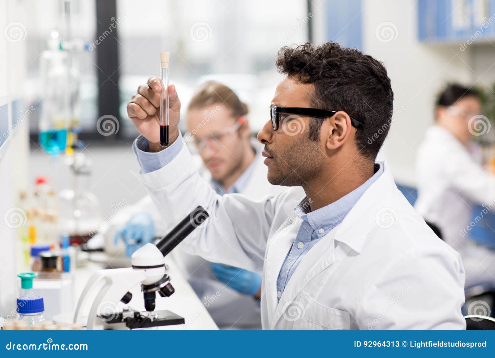 Young Scientist in Eyeglasses Looking at Test Tube in Research ...