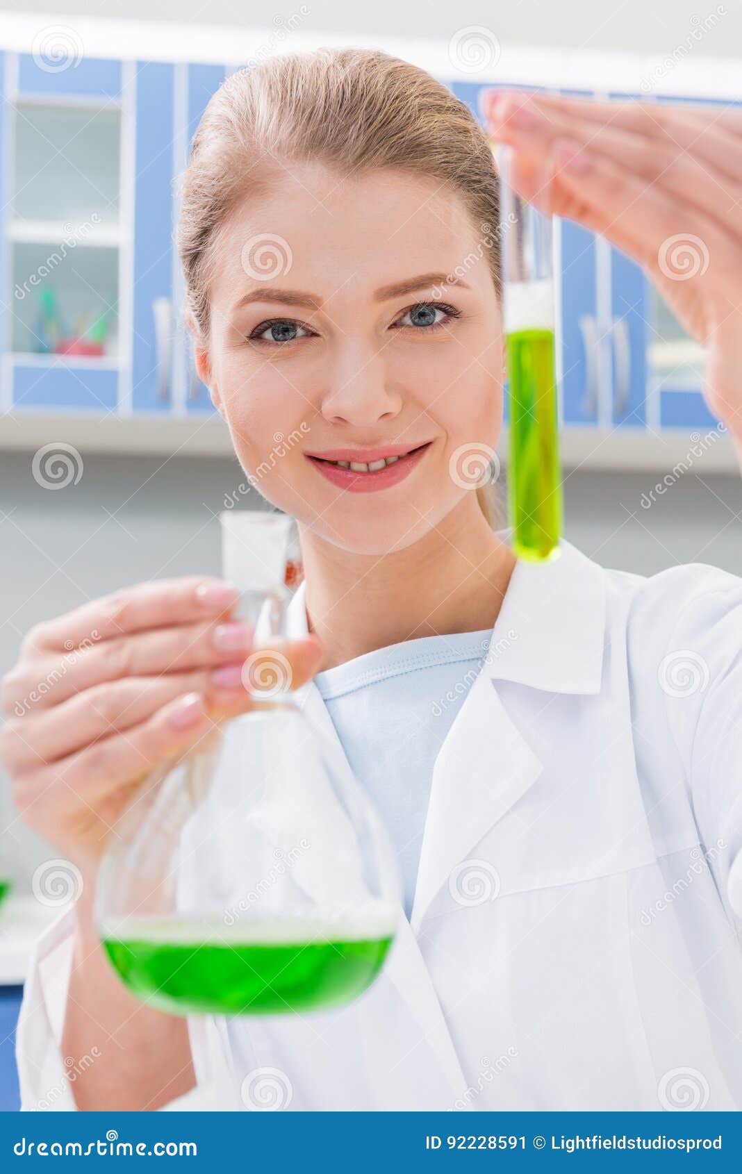 Young Scientist Holding Flasks with Reagents and Smiling at Camera ...