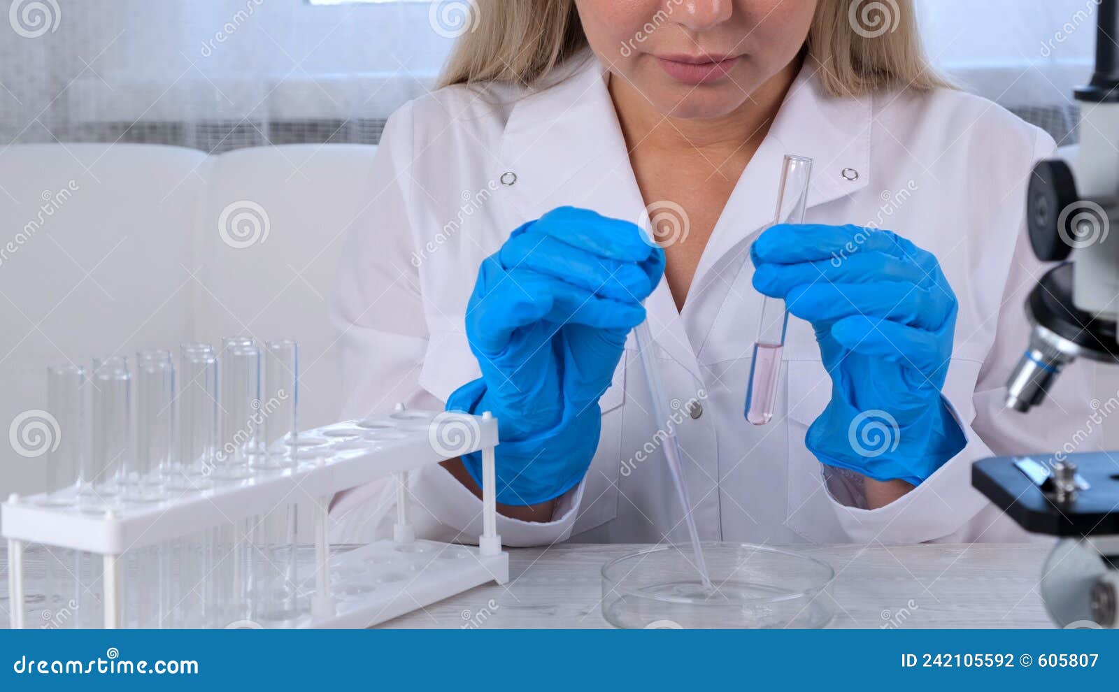 Young Scientist Laboratory Assistant Looks through a Microscope in the ...