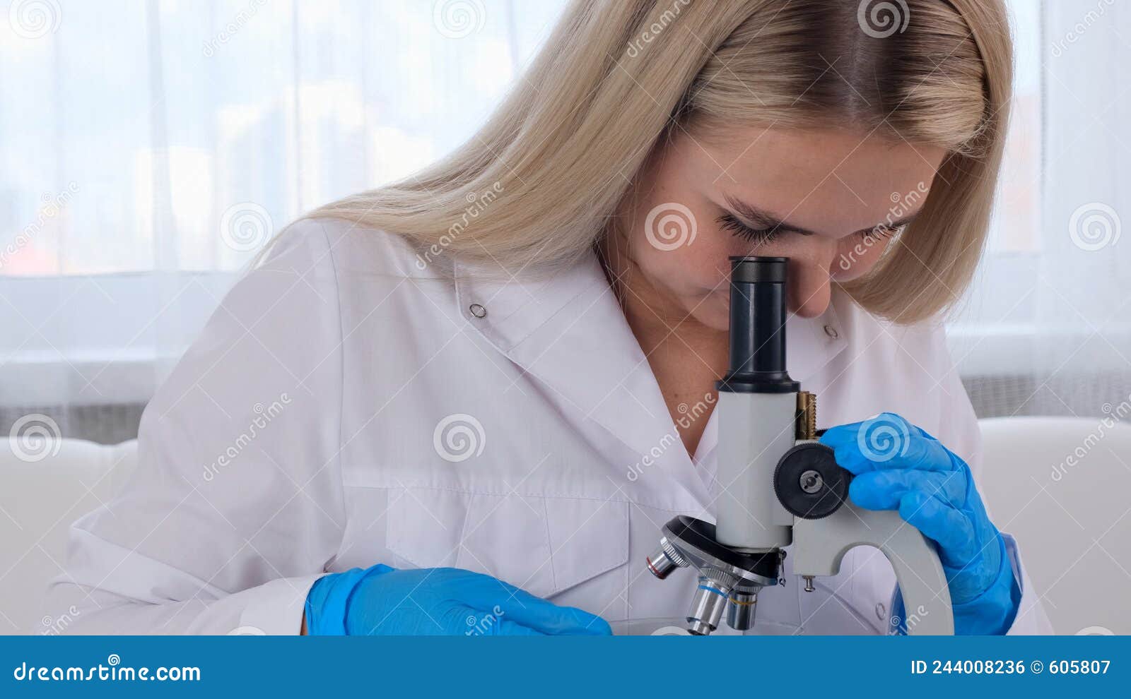 Young Scientist Laboratory Assistant Looks through a Microscope in the ...