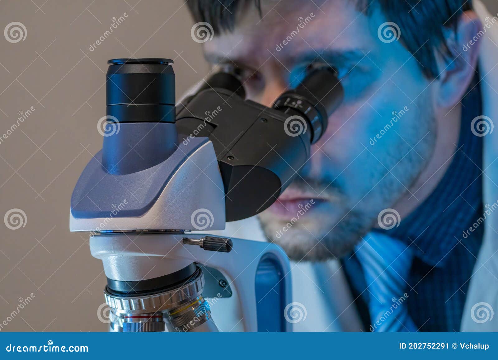 Young Scientist is Looking Inside Microscope in Laboratory. Stock Image ...