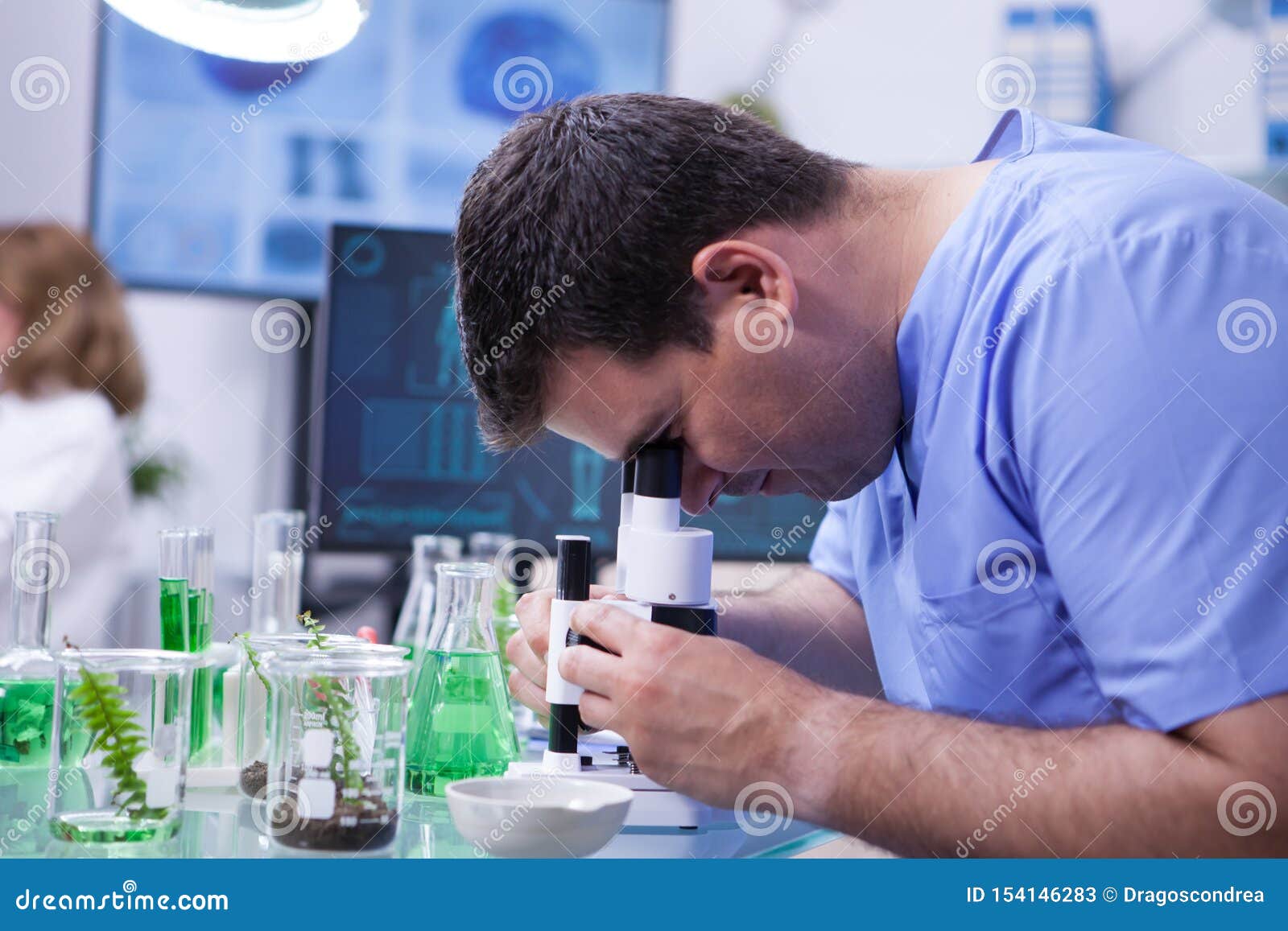 Young Scientist Man Doing a Quality Control Looking through Microscope ...