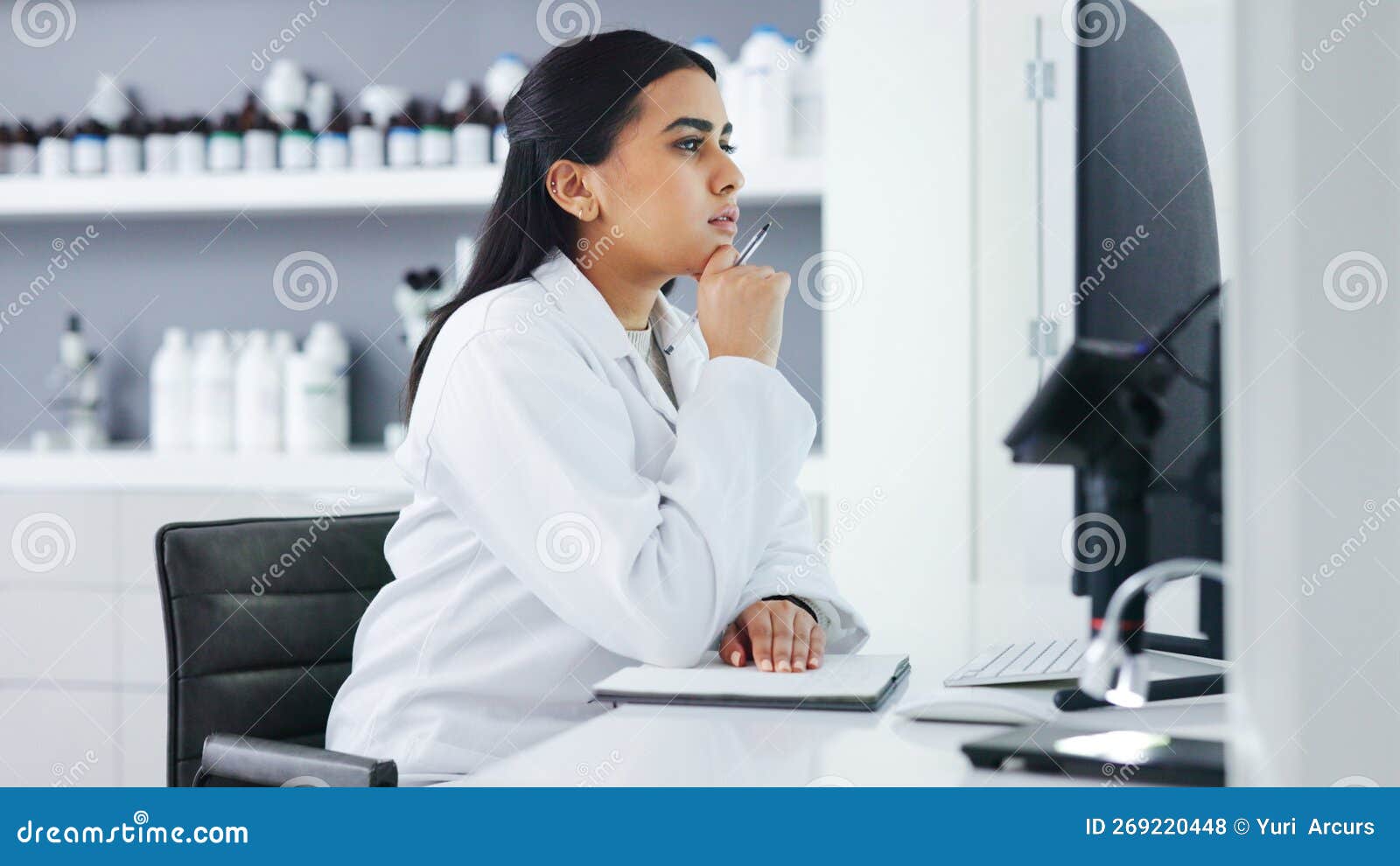 Young Scientist Using a Computer and Microscope in a Lab. Female ...