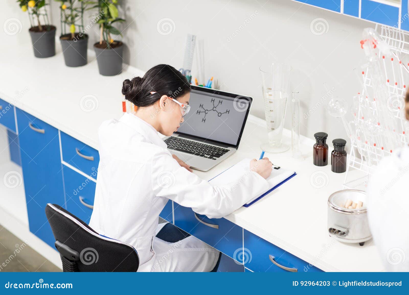 Young Scientist Using Laptop and Writing in Clipboard in Research ...