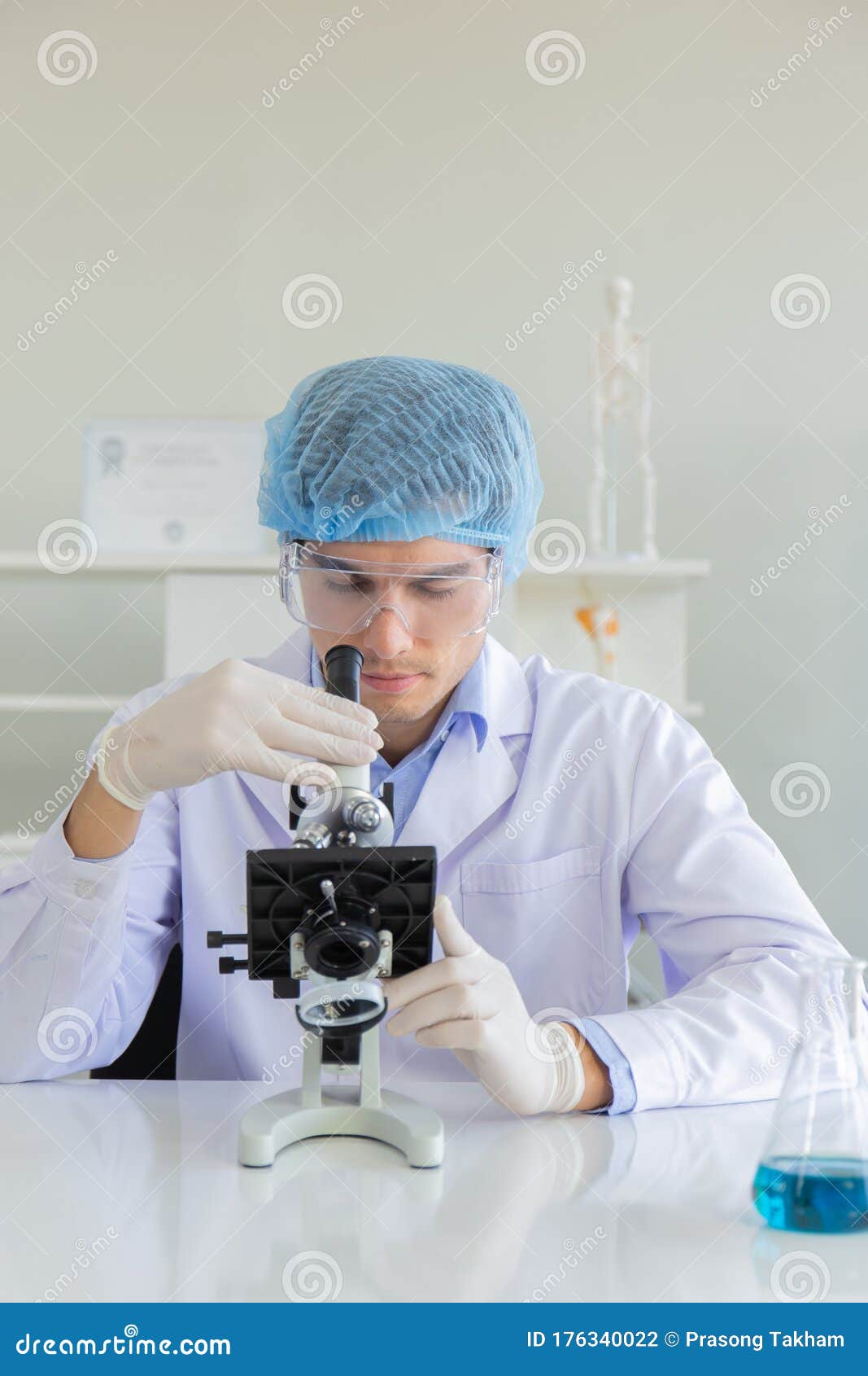 Young Scientist Using Microscope in Laboratory. Male Researcher Wearing ...