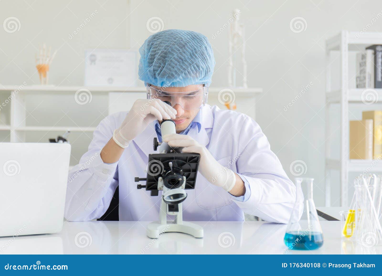 Young Scientist Using Microscope in Laboratory. Male Researcher Wearing ...