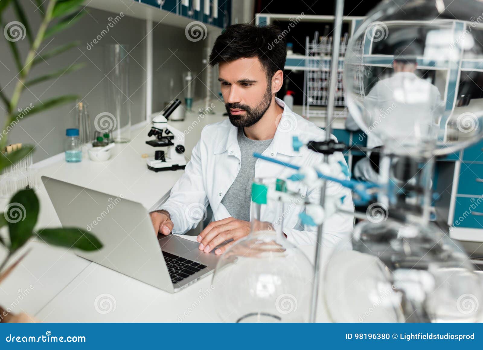 Young Scientist in White Coat Using Laptop in Chemical Lab Stock Photo ...