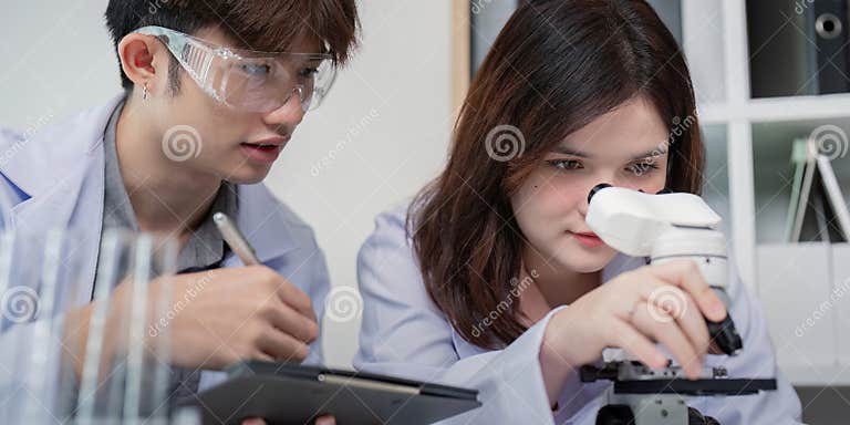 Young Scientists Collaborating in Laboratory for Microscopic Analysis - Concept of Teamwork and ...