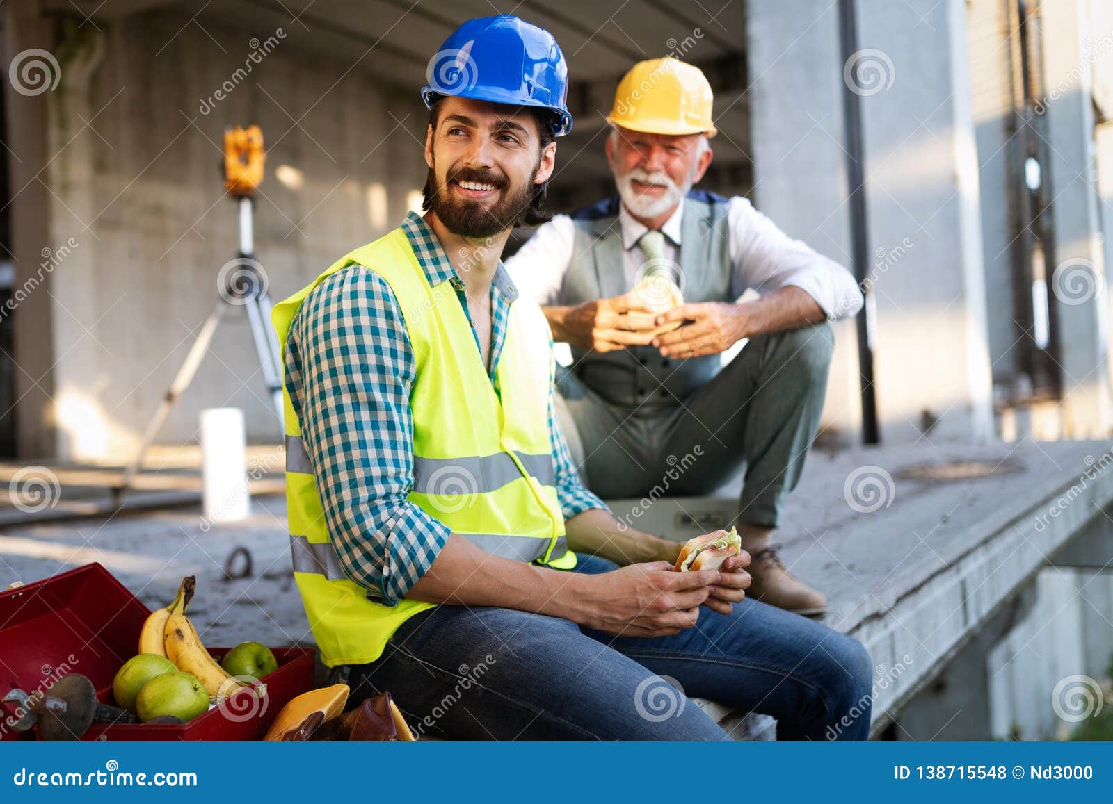 Happy Young and Senior Engineer Worker Sitting at Building Site on ...