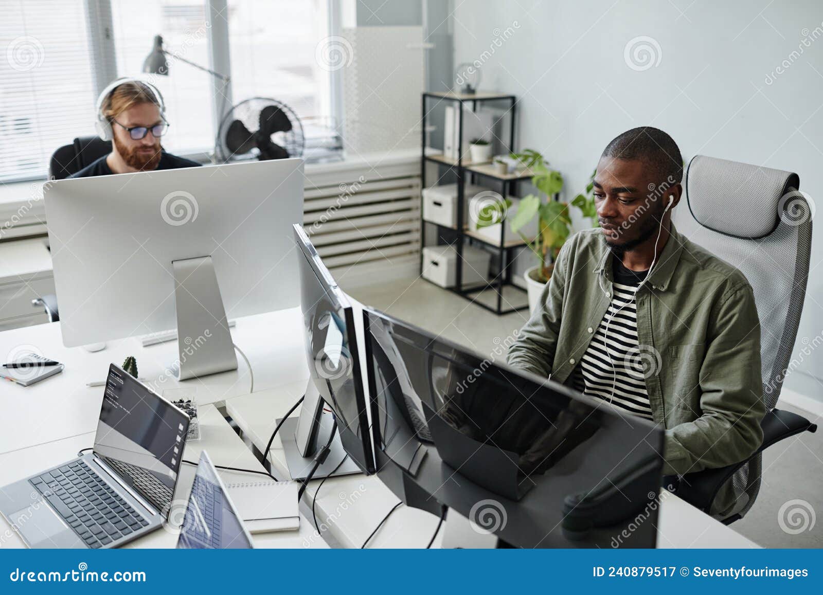 Young Serious Diversity Programmer in Casual Clothes Looking at ...