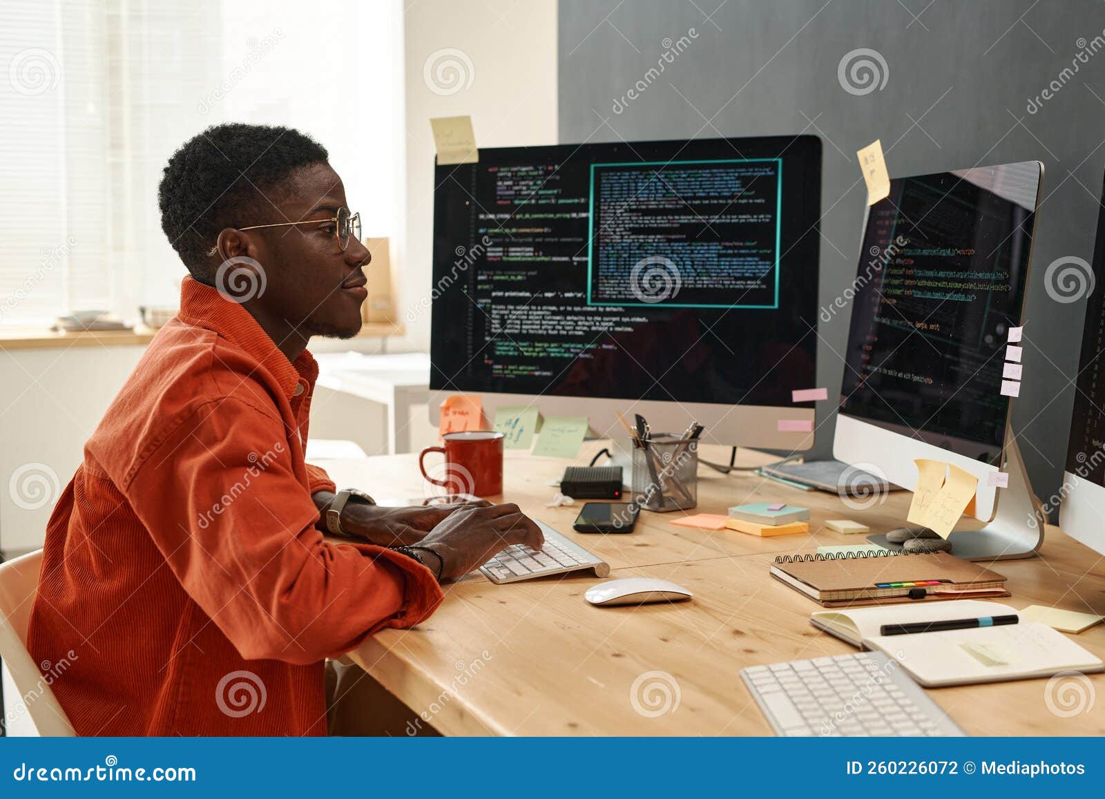 Young Serious it Engineer in Smart Orange Shirt Looking at Coded Data ...