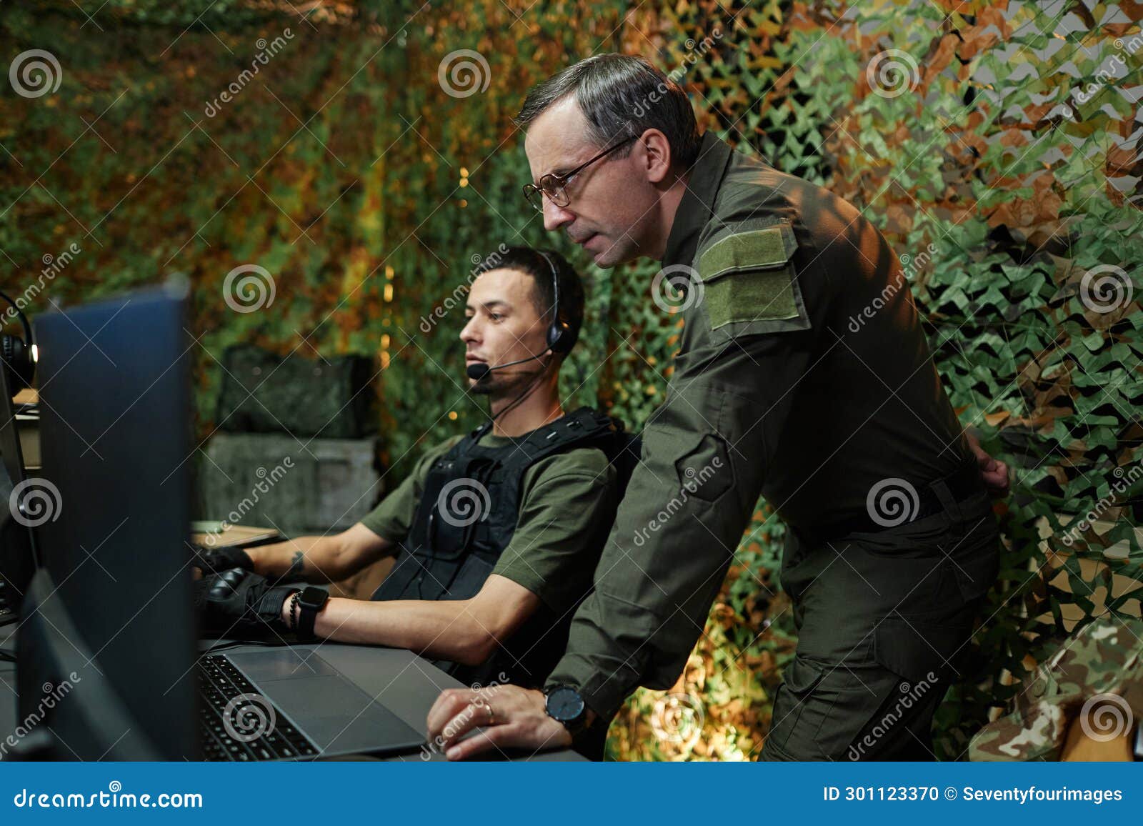 Young Serious Officer of Command and Control Center Looking at Computer ...