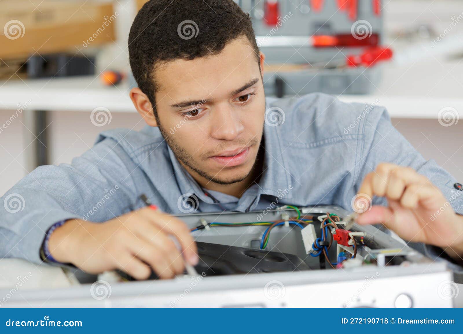 Young Serviceman Working on Broken Washing Machine Stock Photo - Image ...