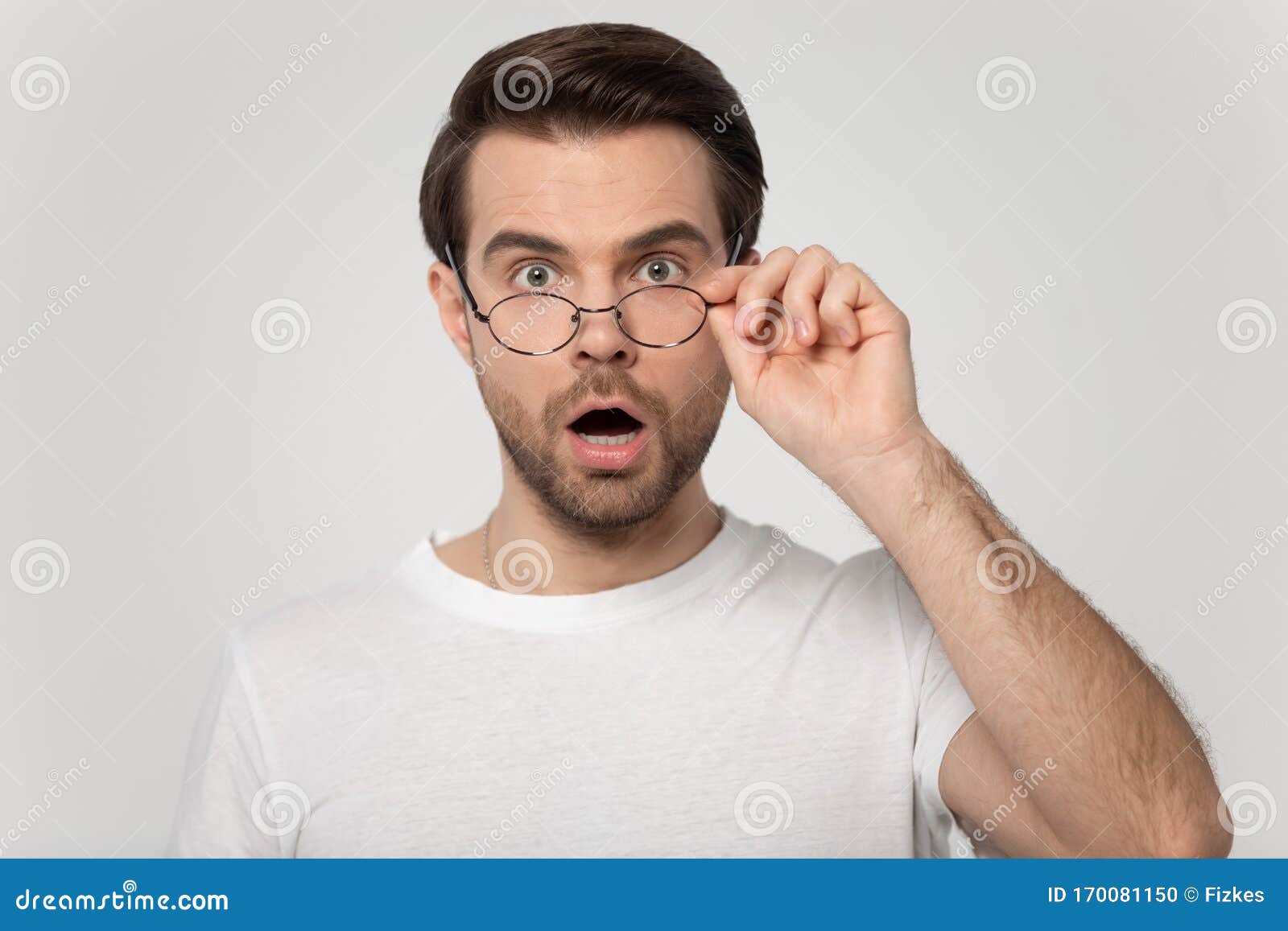 Young Shocked Surprised Man Looking At Camera Taking Off Glasses