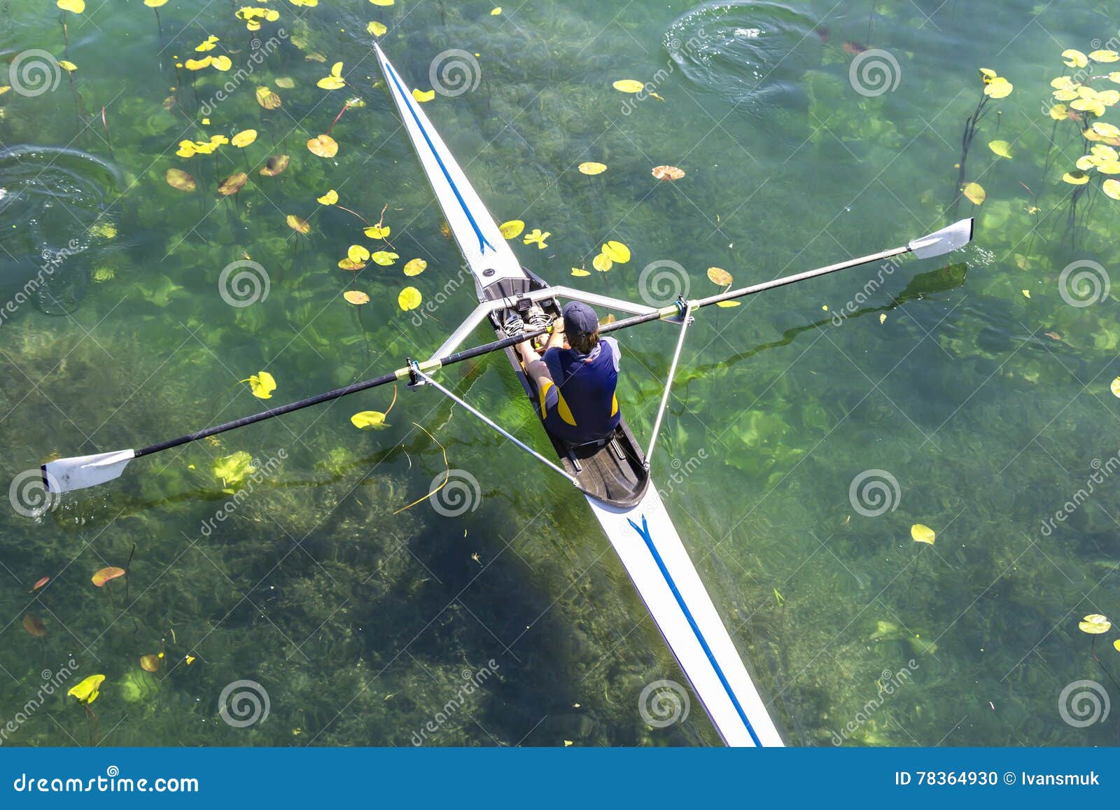 A Young Single Scull Rowing Competitor Paddles on the Tranquil L ...