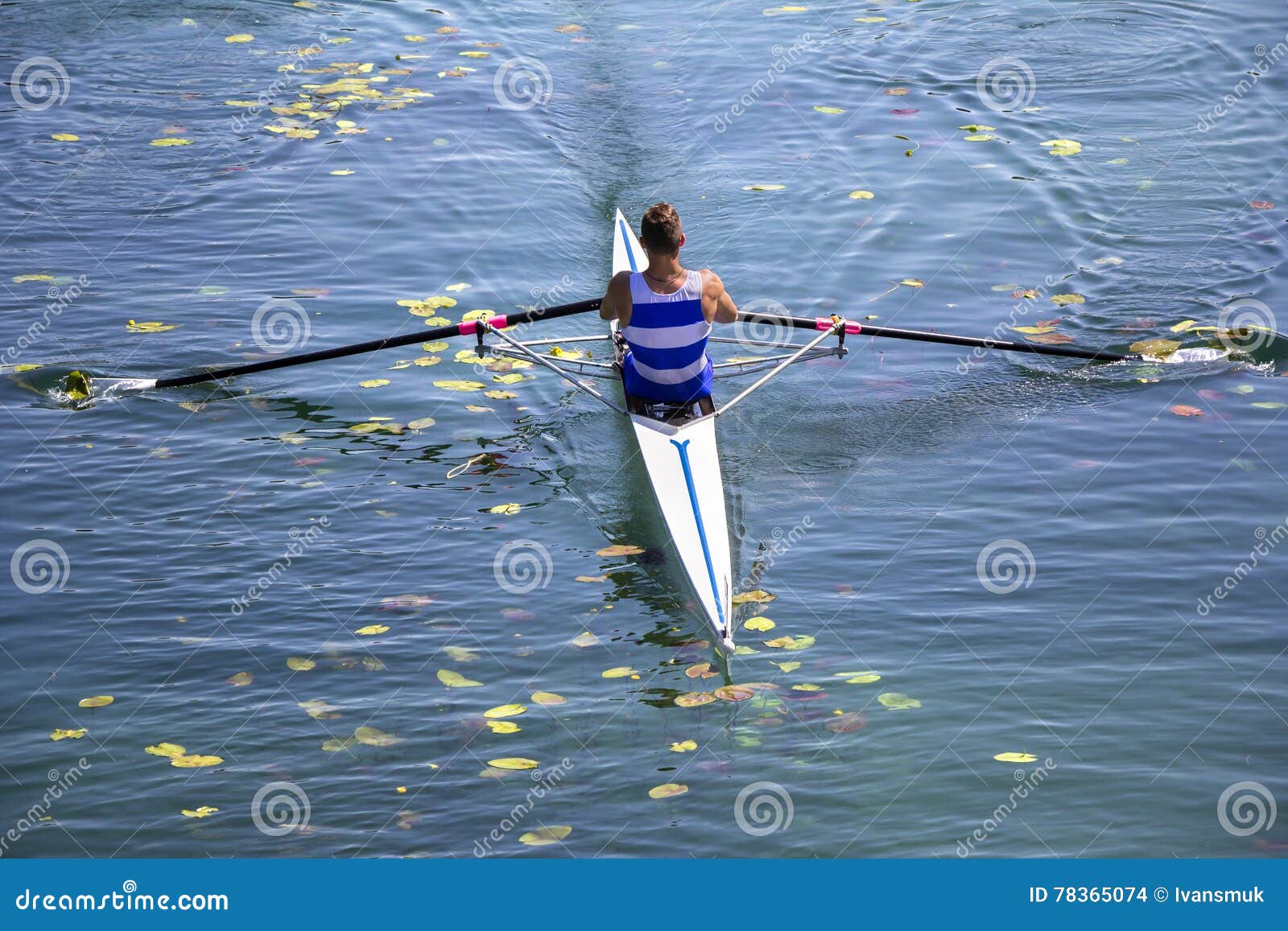 A Young Single Scull Rowing Competitor Paddles on the Tranquil L ...