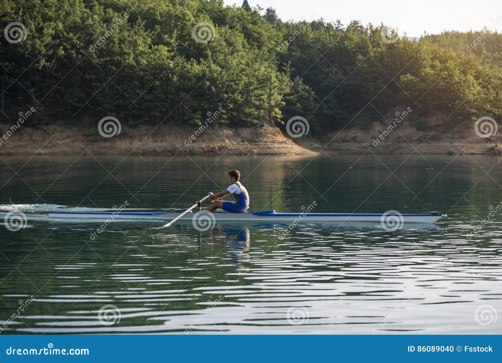 A Young Single Scull Rowing Competitor Paddles on the Tranquil Lake ...