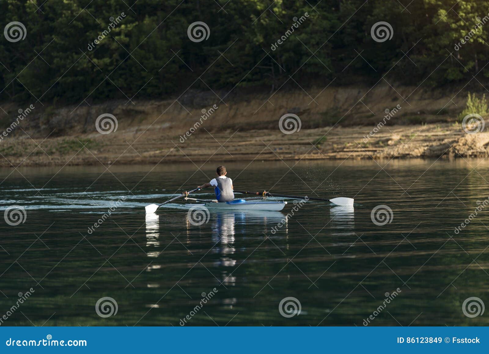 A Young Single Scull Rowing Competitor Paddles on the Tranquil Lake ...