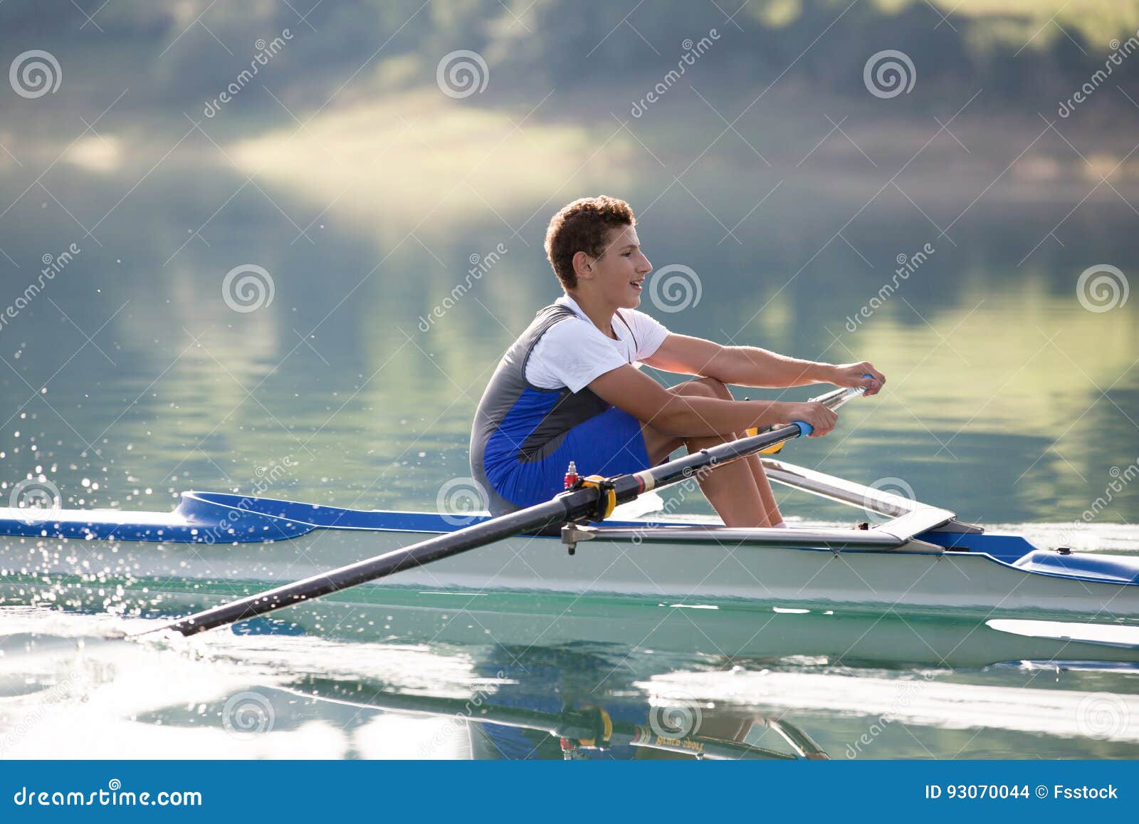A Young Single Scull Rowing Competitor Paddles on the Tranquil Lake ...