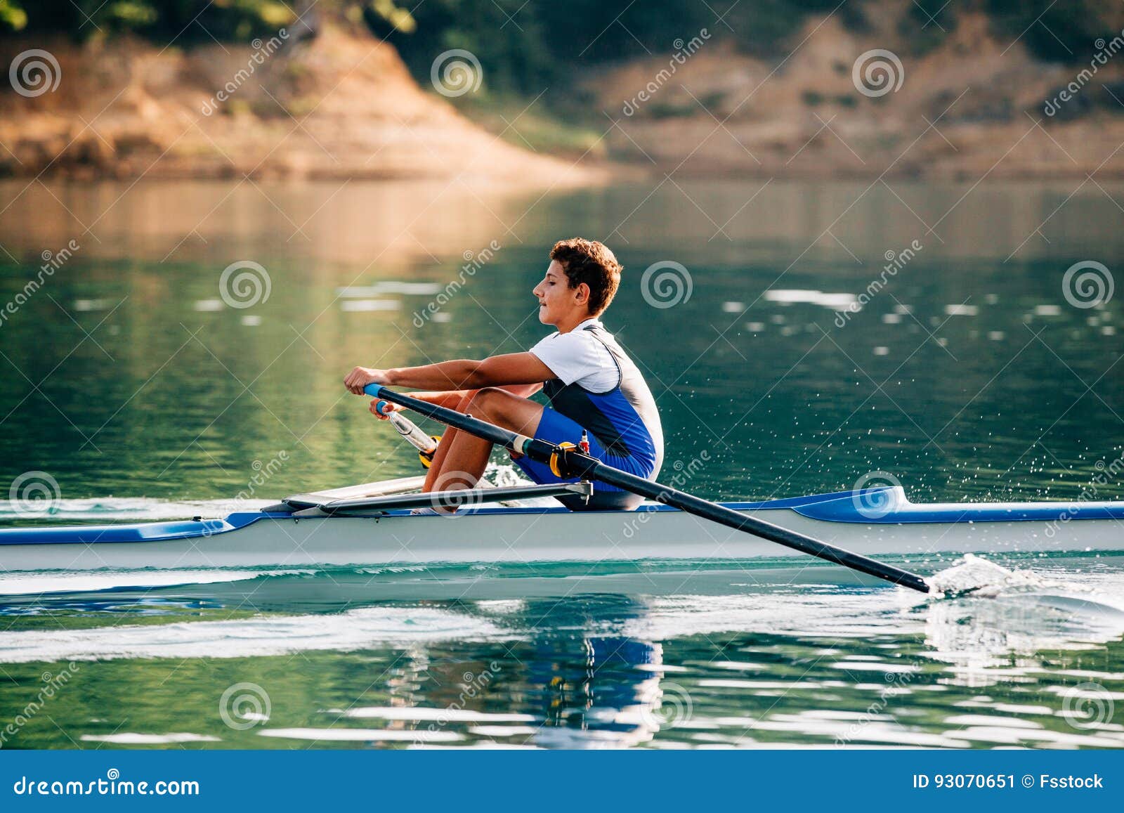 A Young Single Scull Rowing Competitor Paddles on the Tranquil Lake ...
