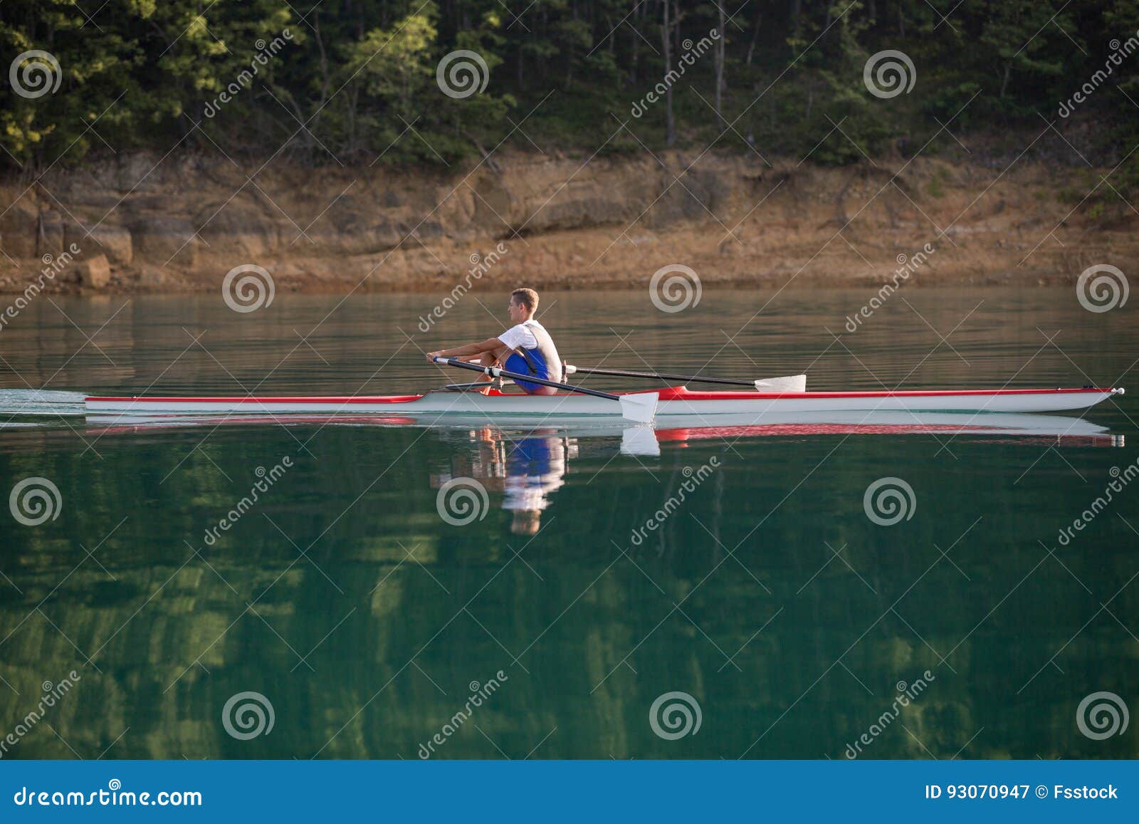 A Young Single Scull Rowing Competitor Paddles on the Tranquil Lake ...