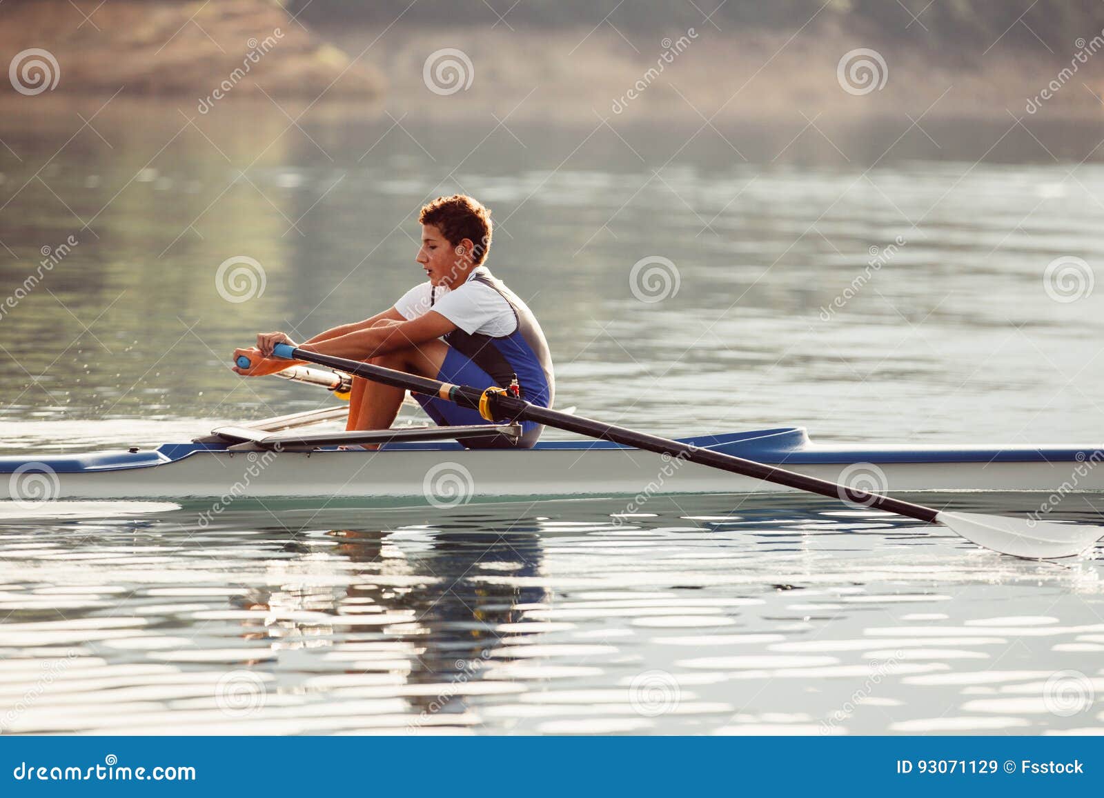 A Young Single Scull Rowing Competitor Paddles on the Tranquil Lake ...