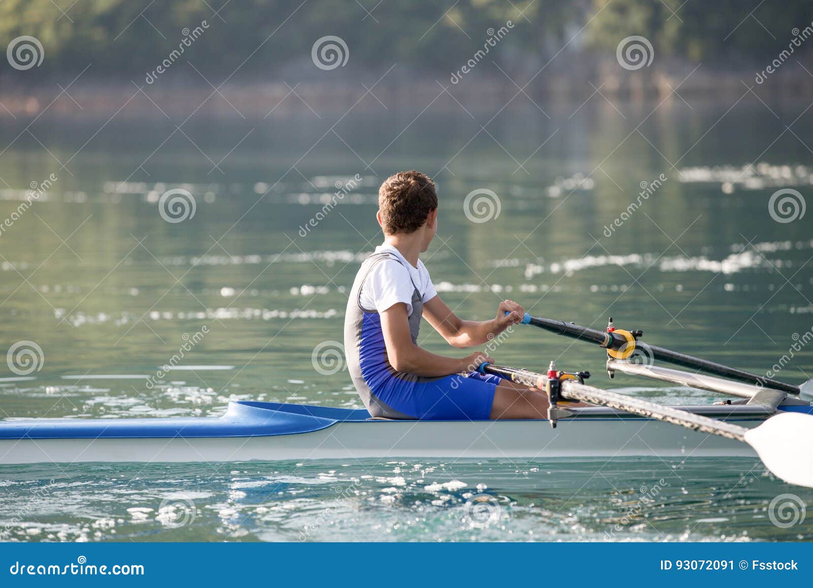 A Young Single Scull Rowing Competitor Paddles on the Tranquil Lake ...