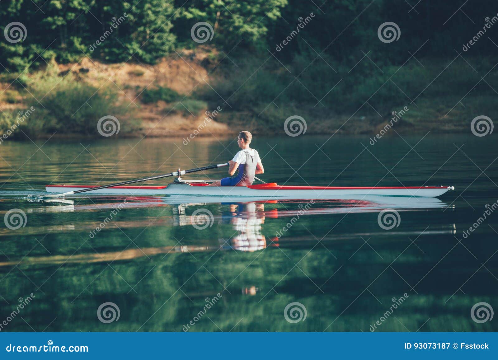 A Young Single Scull Rowing Competitor Paddles on the Tranquil Lake ...