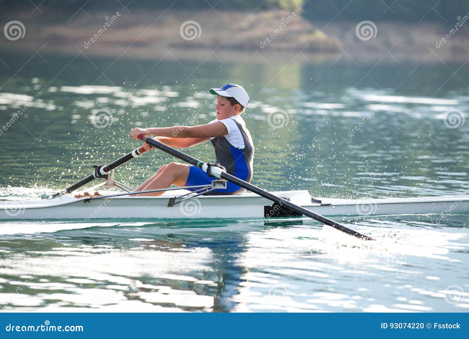A Young Single Scull Rowing Competitor Paddles on the Tranquil Lake ...