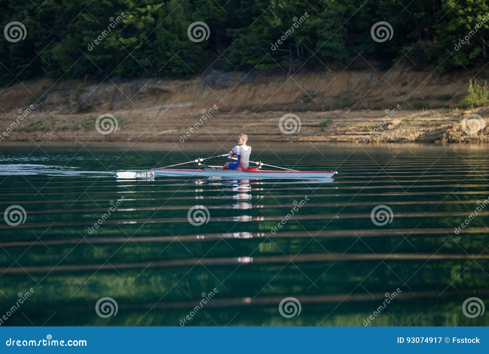 A Young Single Scull Rowing Competitor Paddles on the Tranquil Lake ...