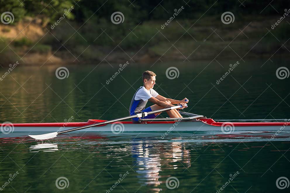 A Young Single Scull Rowing Competitor Paddles on the Tranquil Lake ...