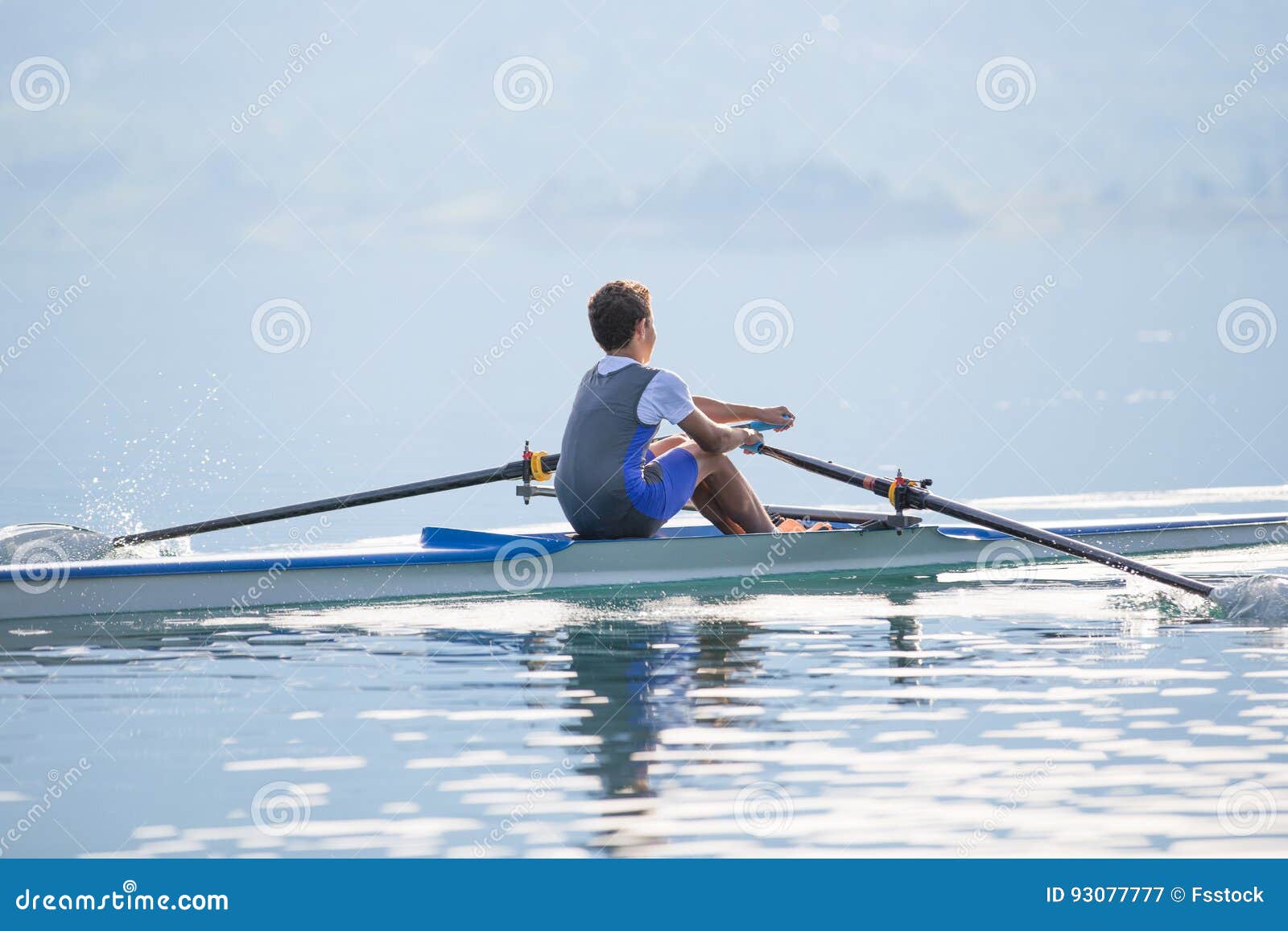 A Young Single Scull Rowing Competitor Paddles on the Tranquil Lake ...