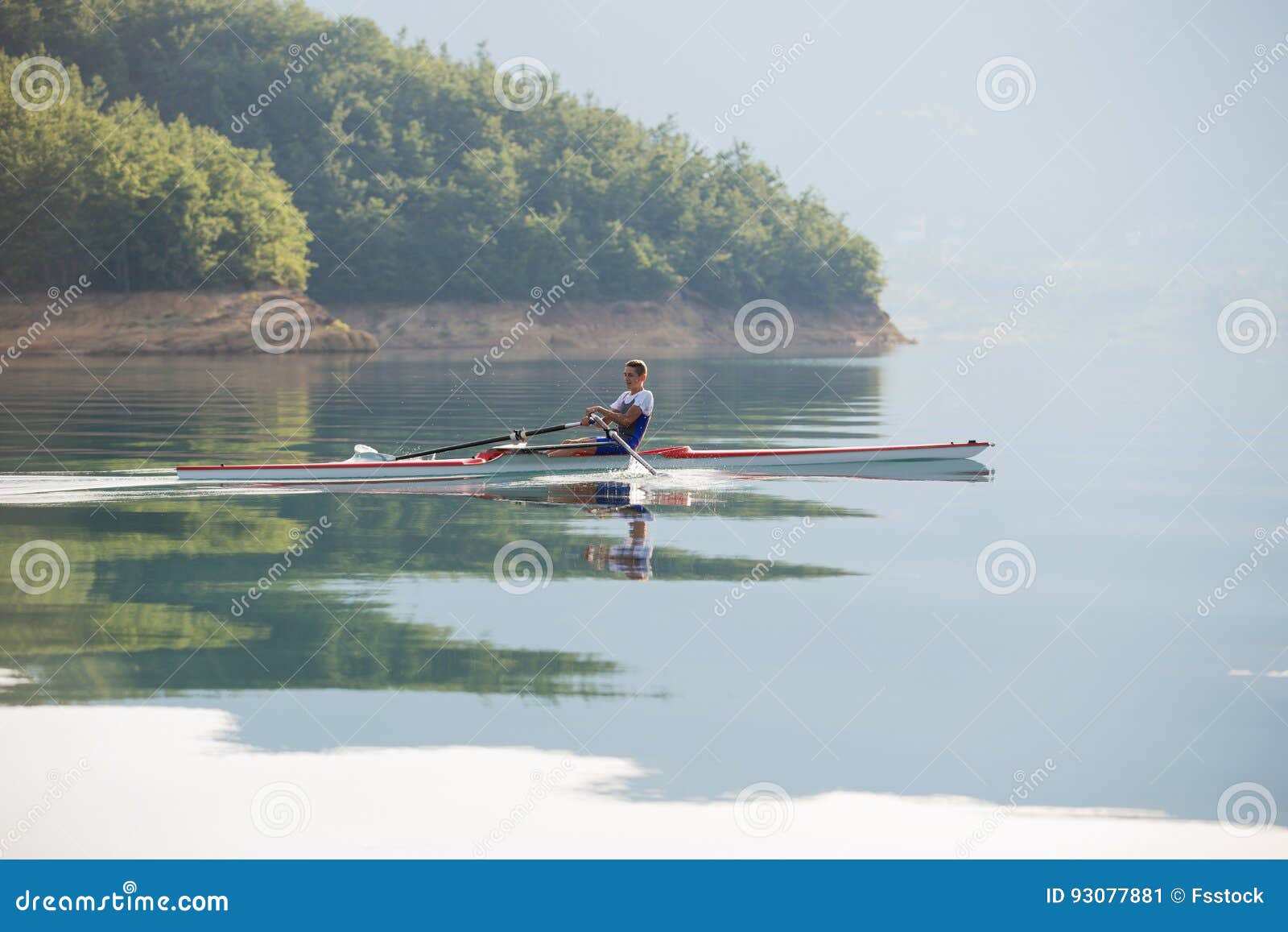 A Young Single Scull Rowing Competitor Paddles on the Tranquil Lake ...