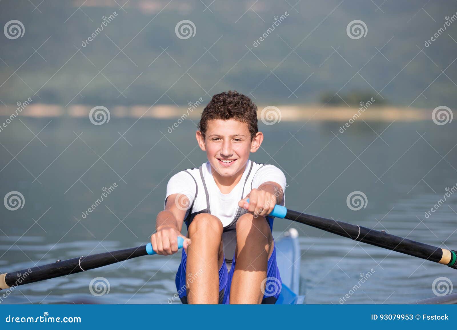 A Young Single Scull Rowing Competitor Paddles on the Tranquil Lake ...