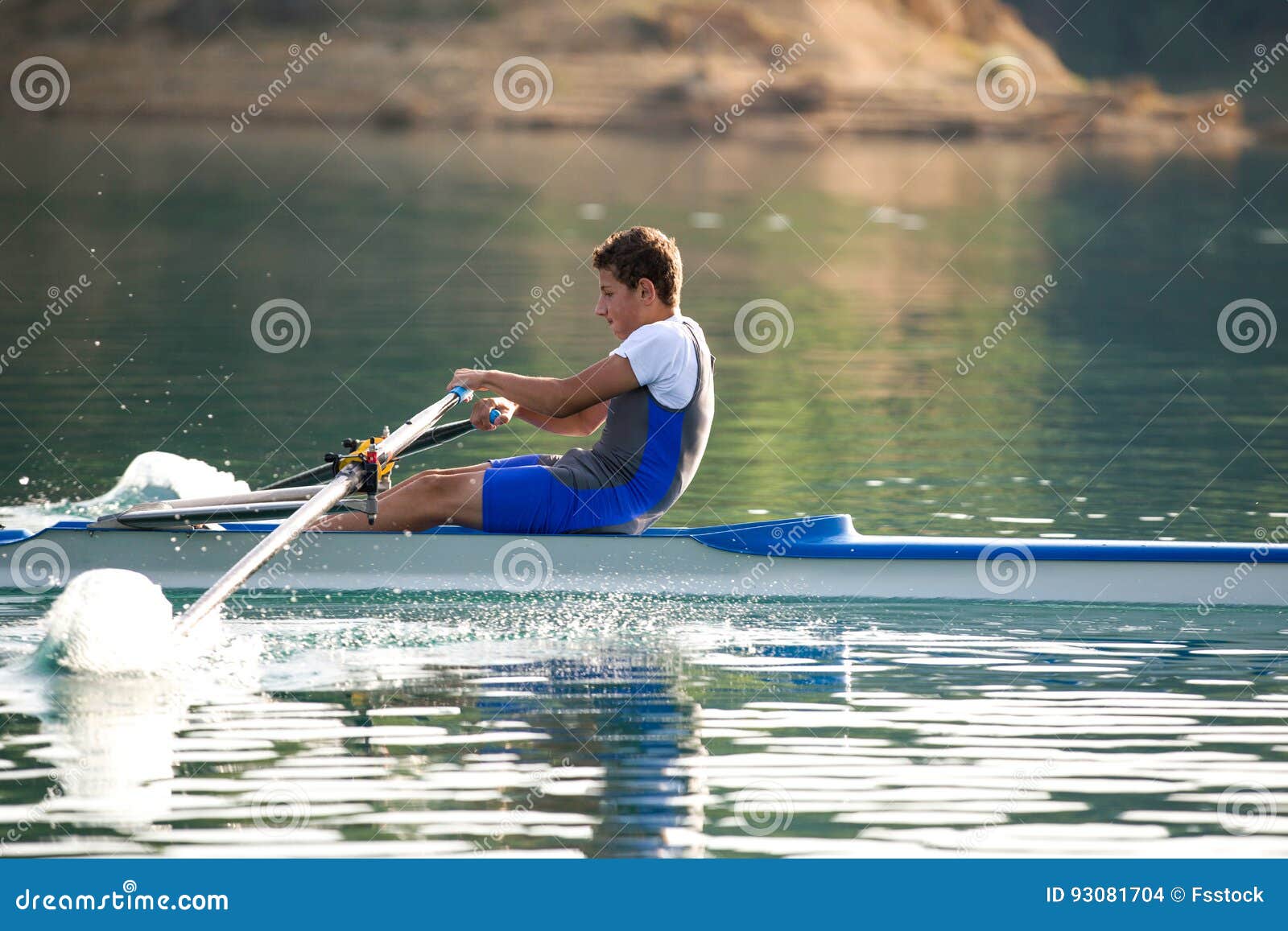 A Young Single Scull Rowing Competitor Paddles on the Tranquil Lake ...
