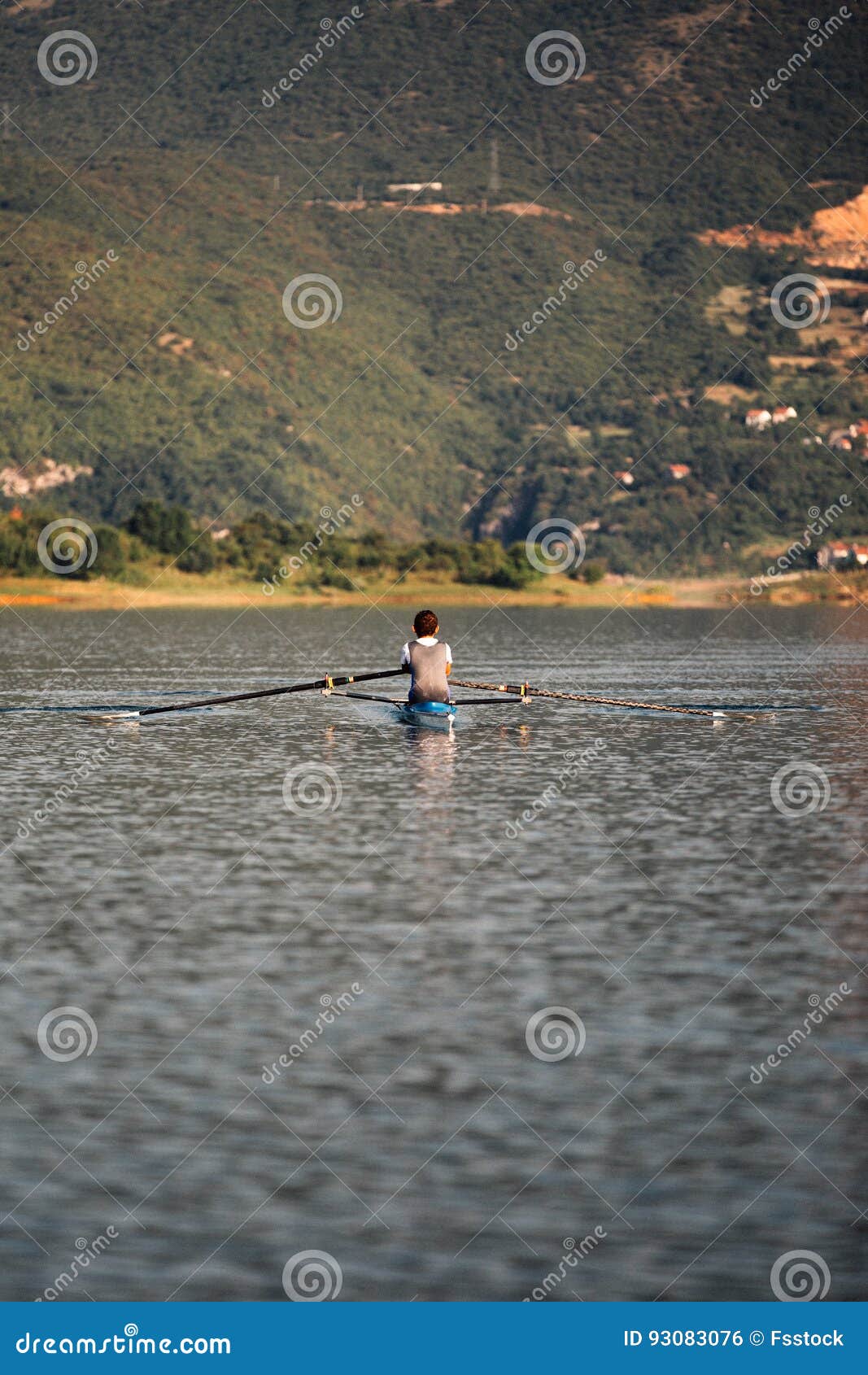A Young Single Scull Rowing Competitor Paddles on the Tranquil Lake ...