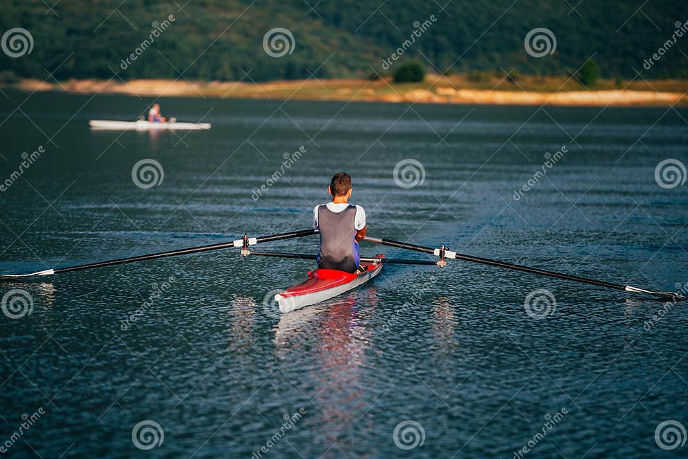 A Young Single Scull Rowing Competitor Paddles on the Tranquil Lake ...