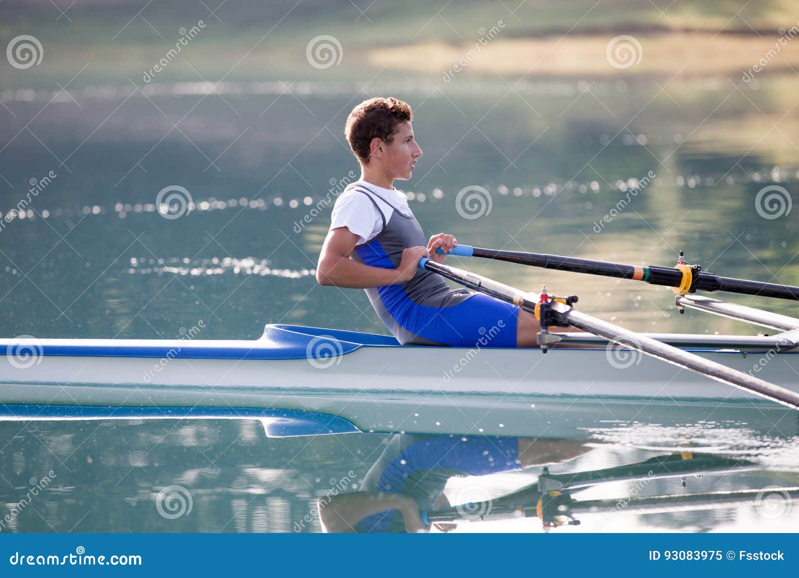 A Young Single Scull Rowing Competitor Paddles on the Tranquil Lake ...