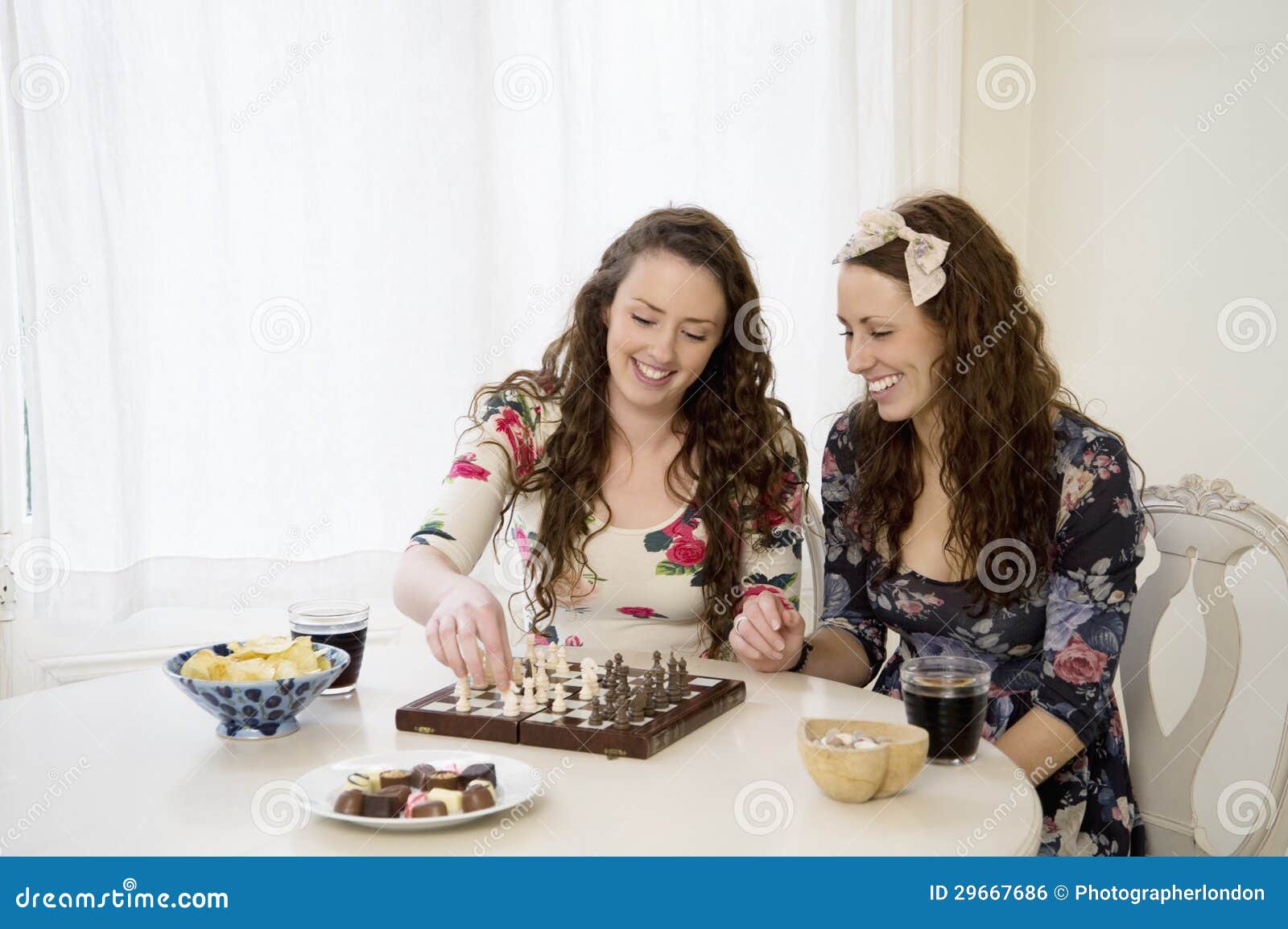 Young Sisters Playing a Game of Chess Stock Photo - Image of adults ...