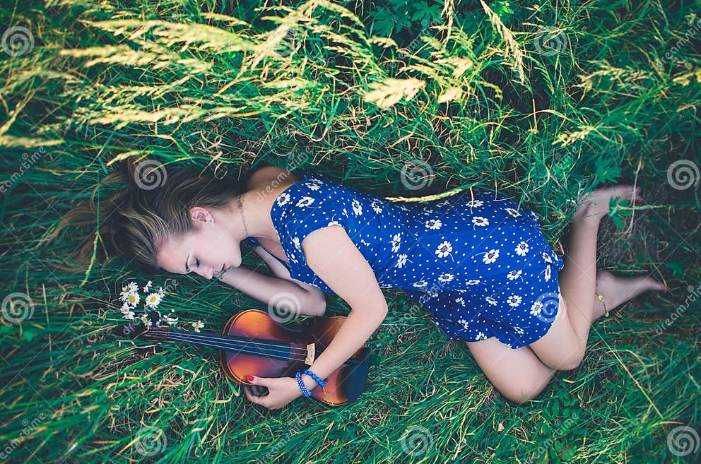Young Slim Fair Skinned Girl Blonde Beautiful Lies In Tall Grass Girl
