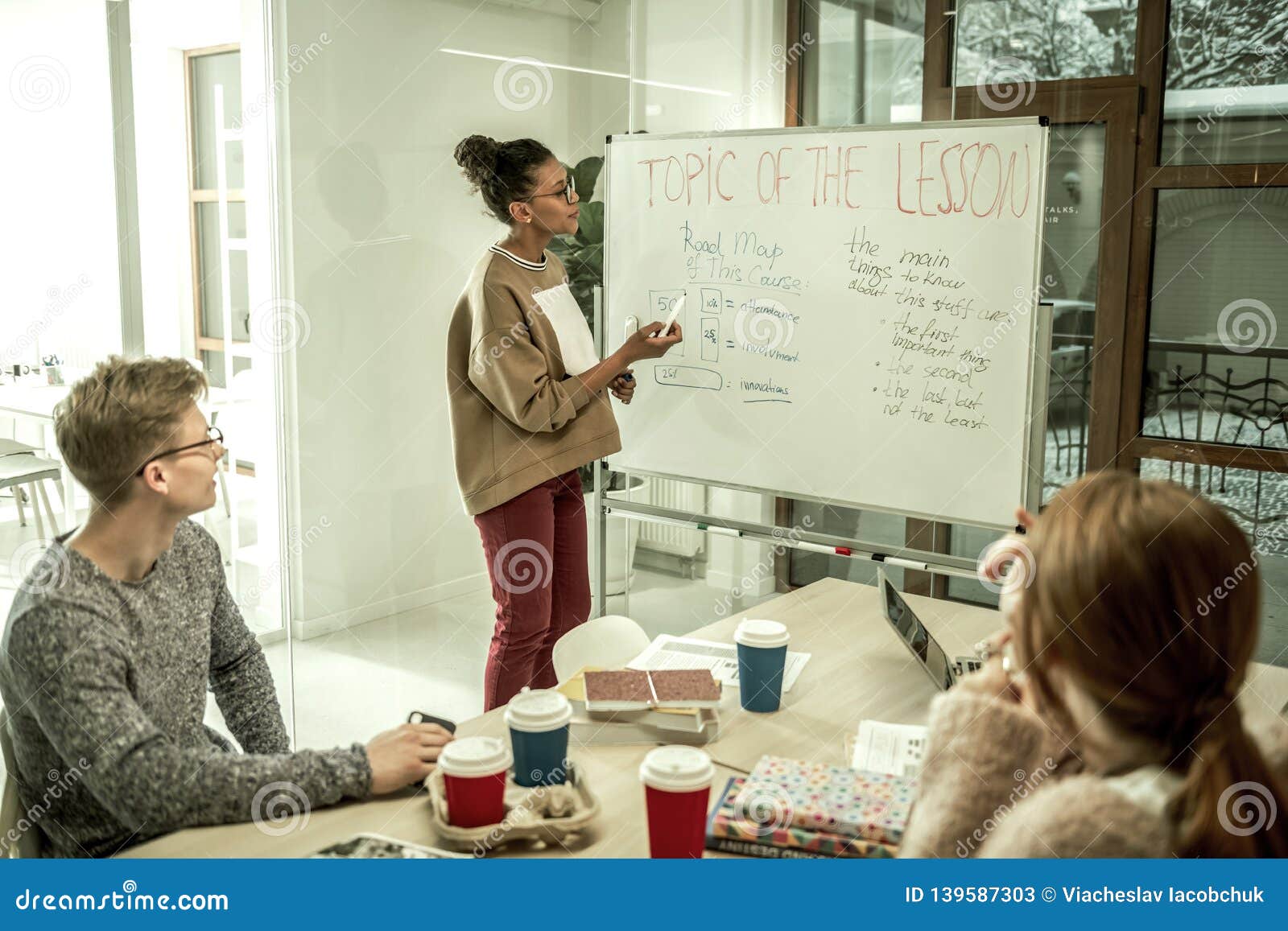 Young Smart Teacher Explaining Topic of the Lesson To Her Students ...