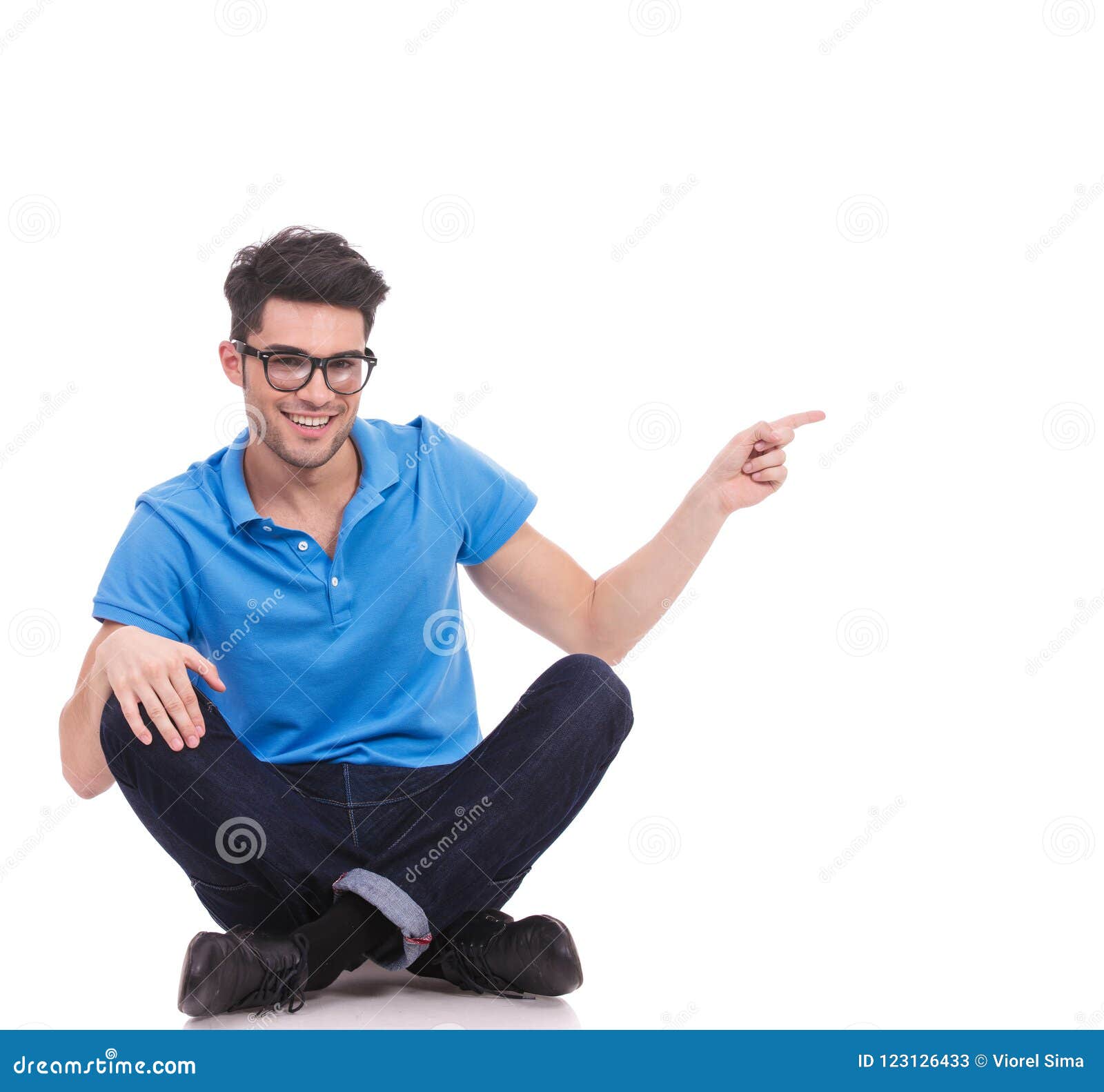 Young Smiling Casual Man Sitting and Pointing To Side Stock Image ... Young Smiling Casual Man Sitting and Pointing To Side Stock Image ...