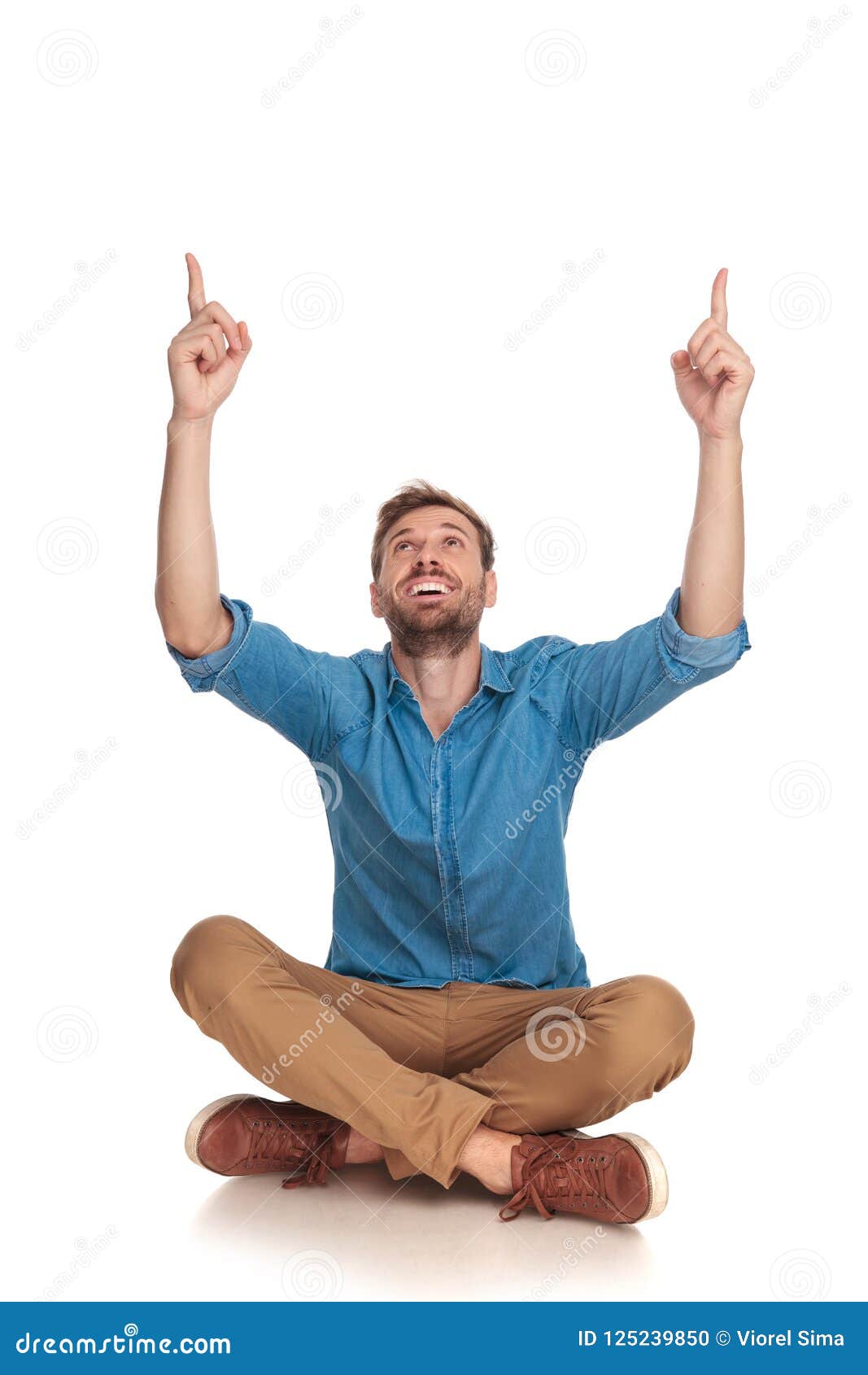 Young Smiling Casual Man is Sitting and Pointing Up Stock Photo - Image ... Young Smiling Casual Man is Sitting and Pointing Up Stock Photo - Image ...